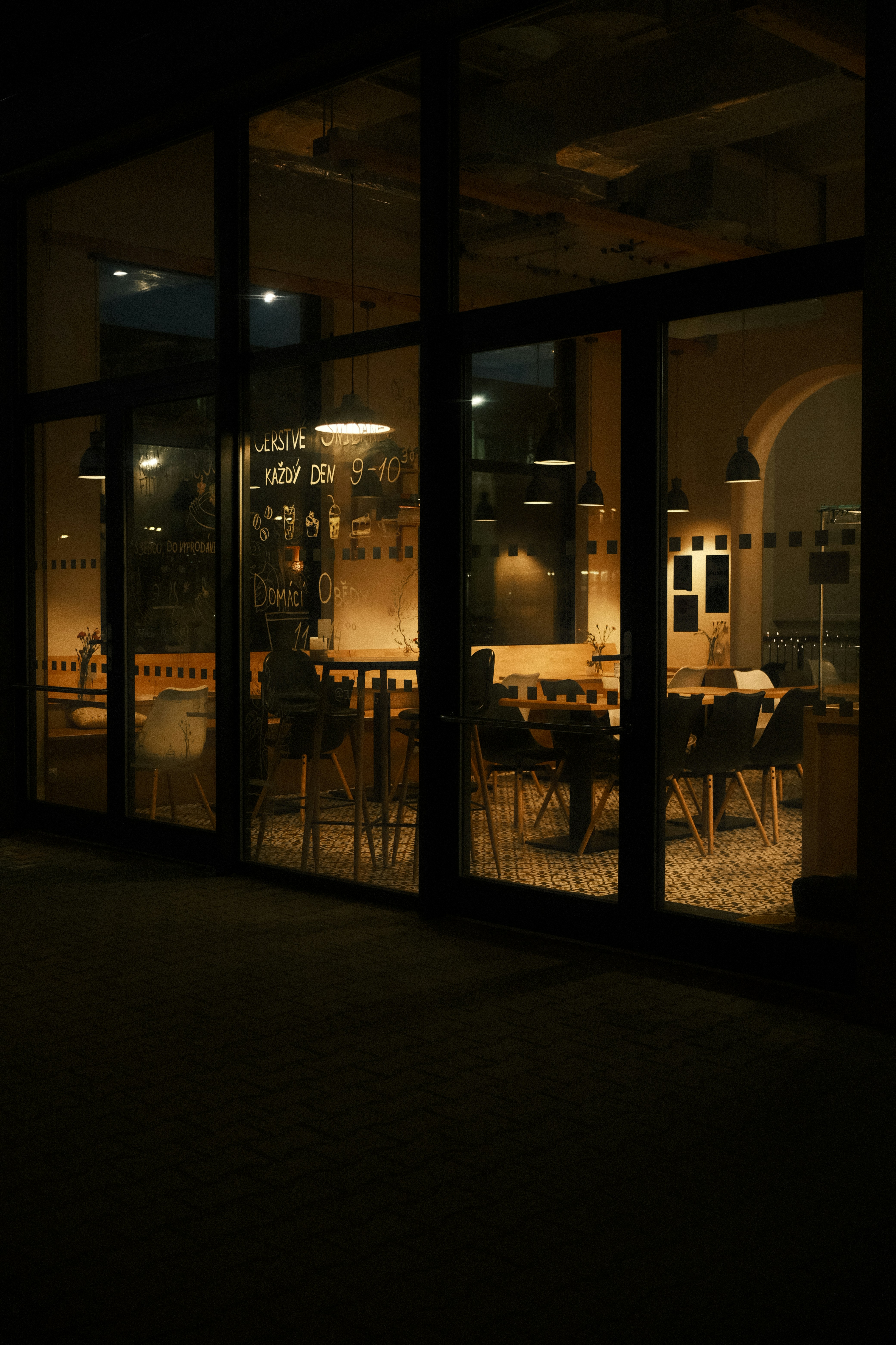 A dimly lit restaurant is seen through windows. photo – Free Food Image ...