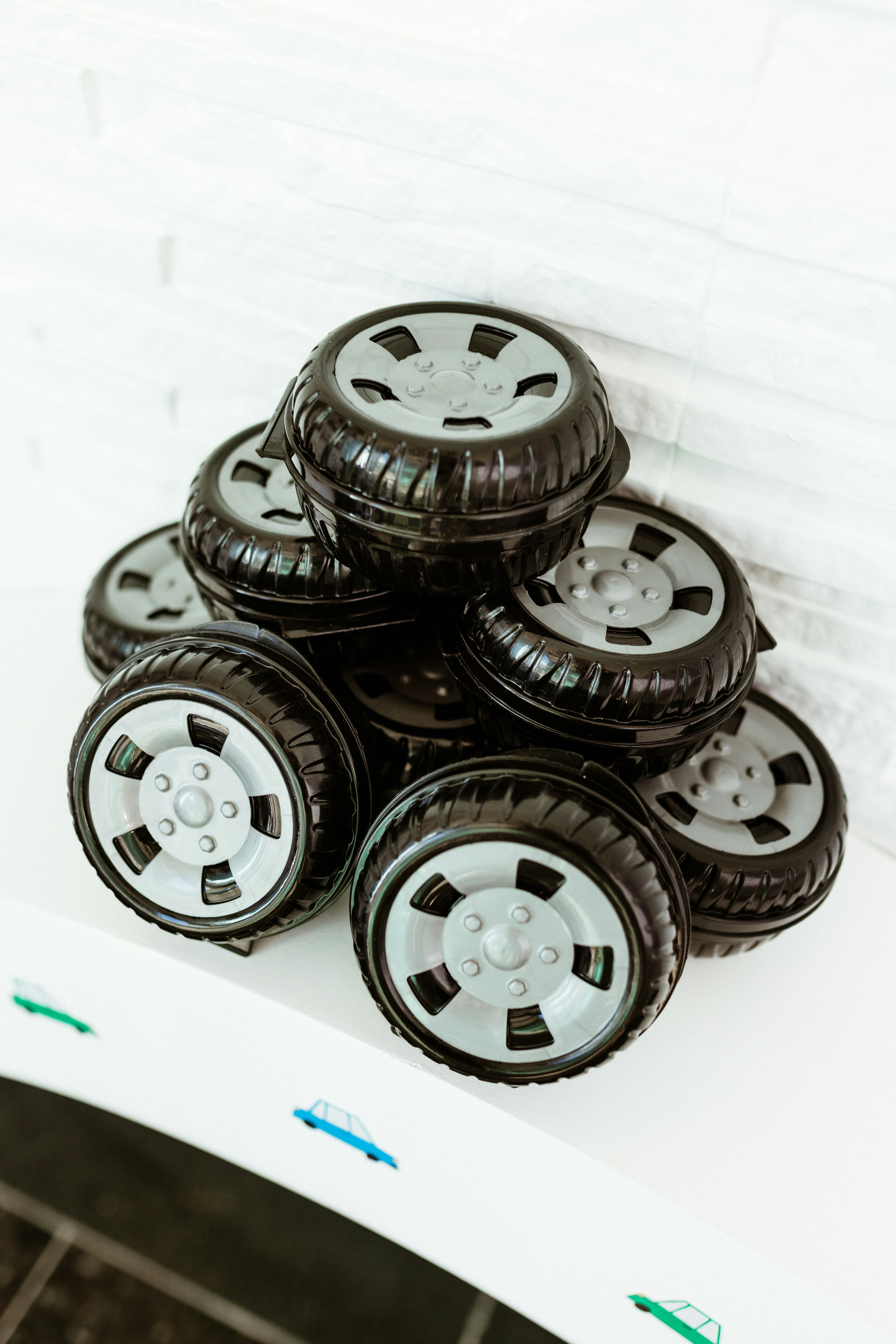 A stack of toy wheels rests against a wall. photo – Free Car Image on ...