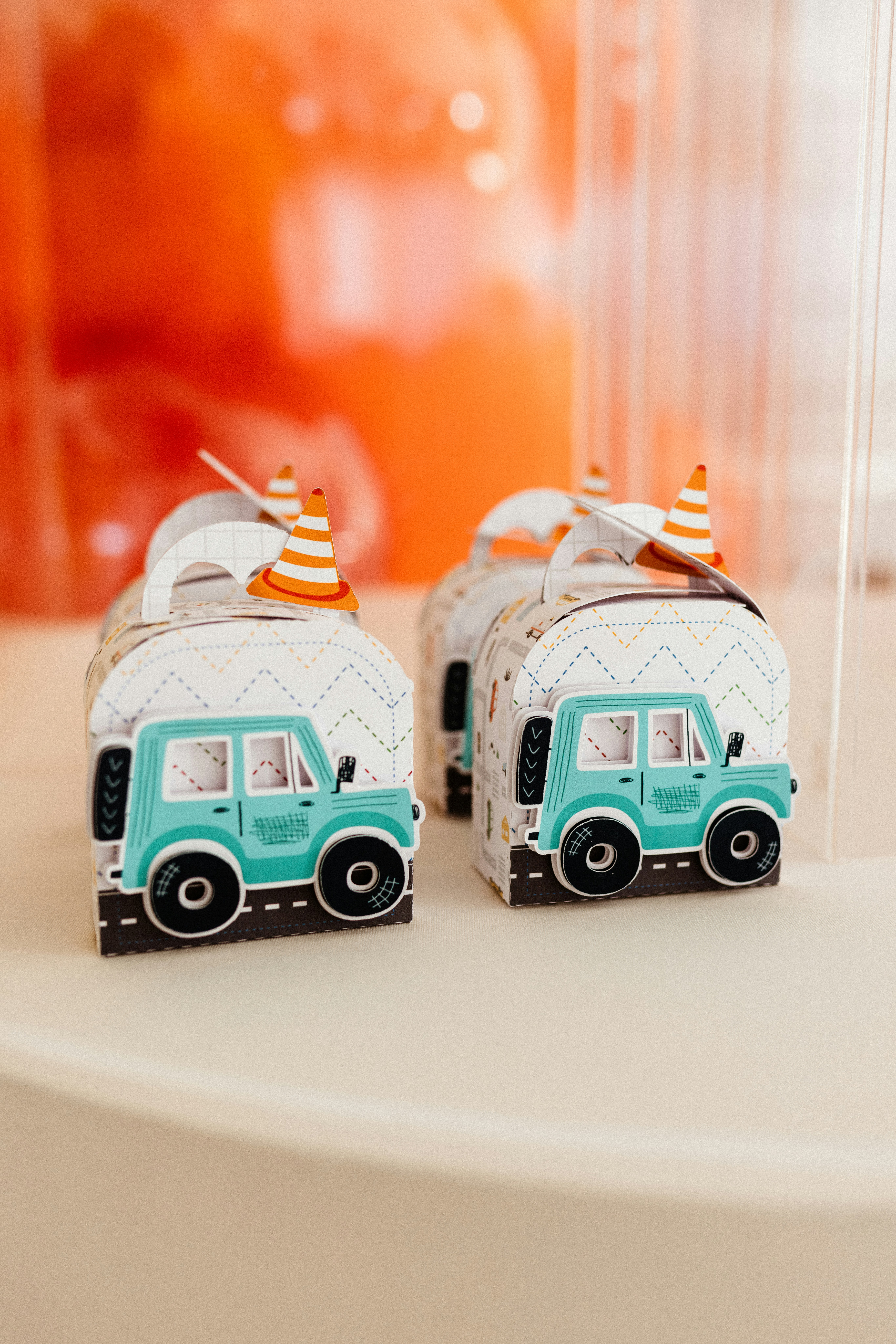 Miniature Toy Cars with Party Hats on a Curved Shelf