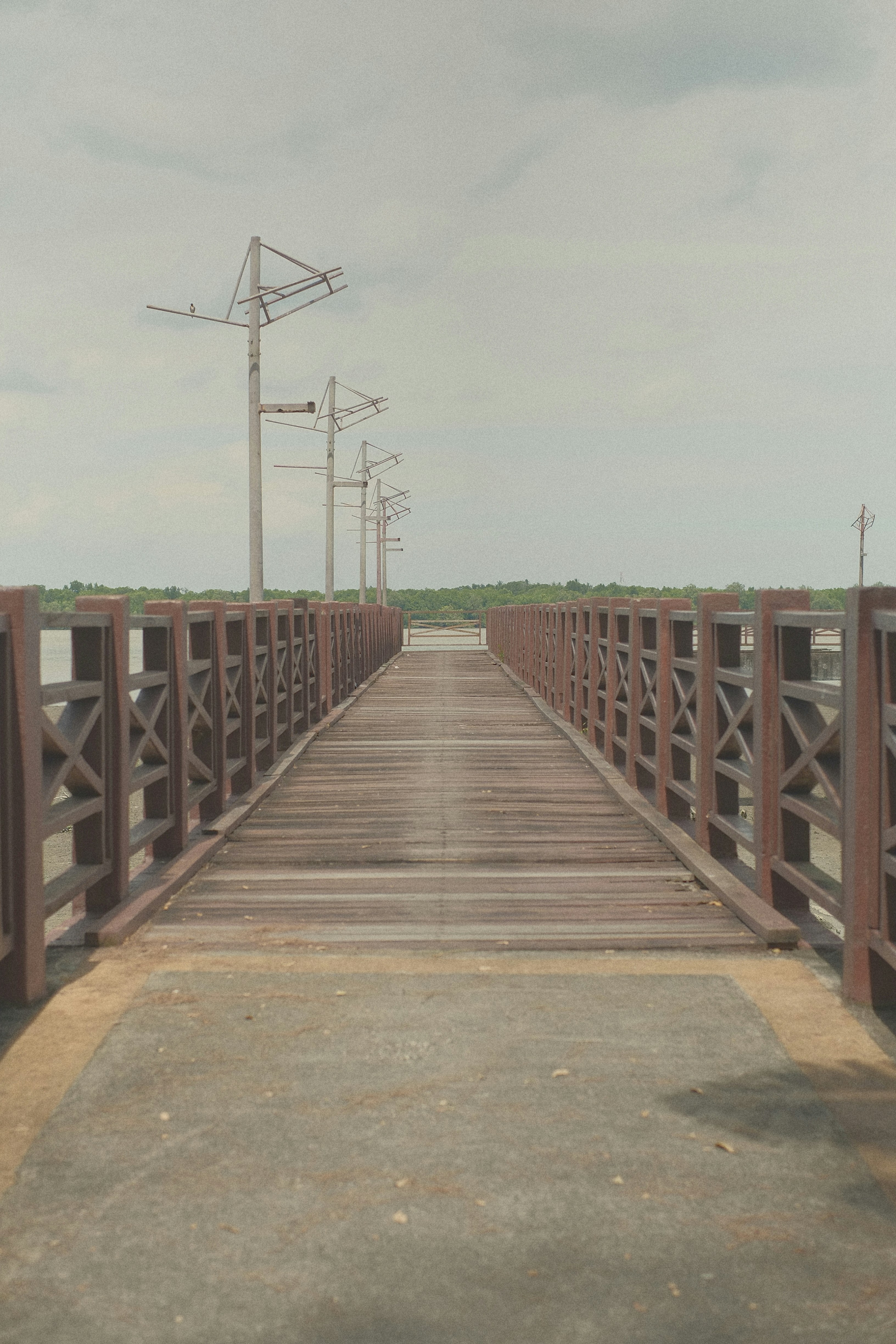 Vanishing Point on a Weathered Pier: Rails Toward a Distant Shore