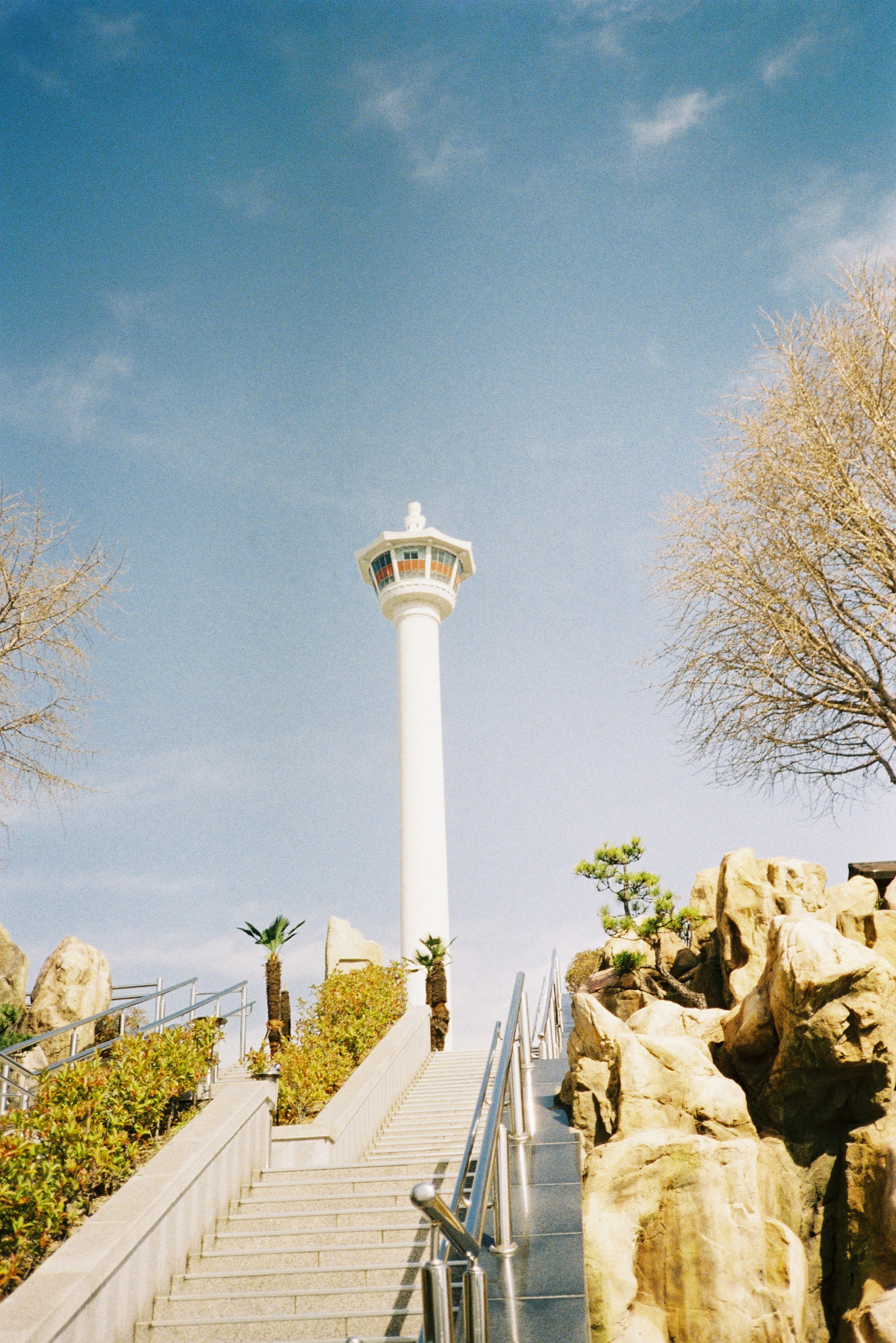 Busan Tower again | A tall white tower stands beneath a blue sky.