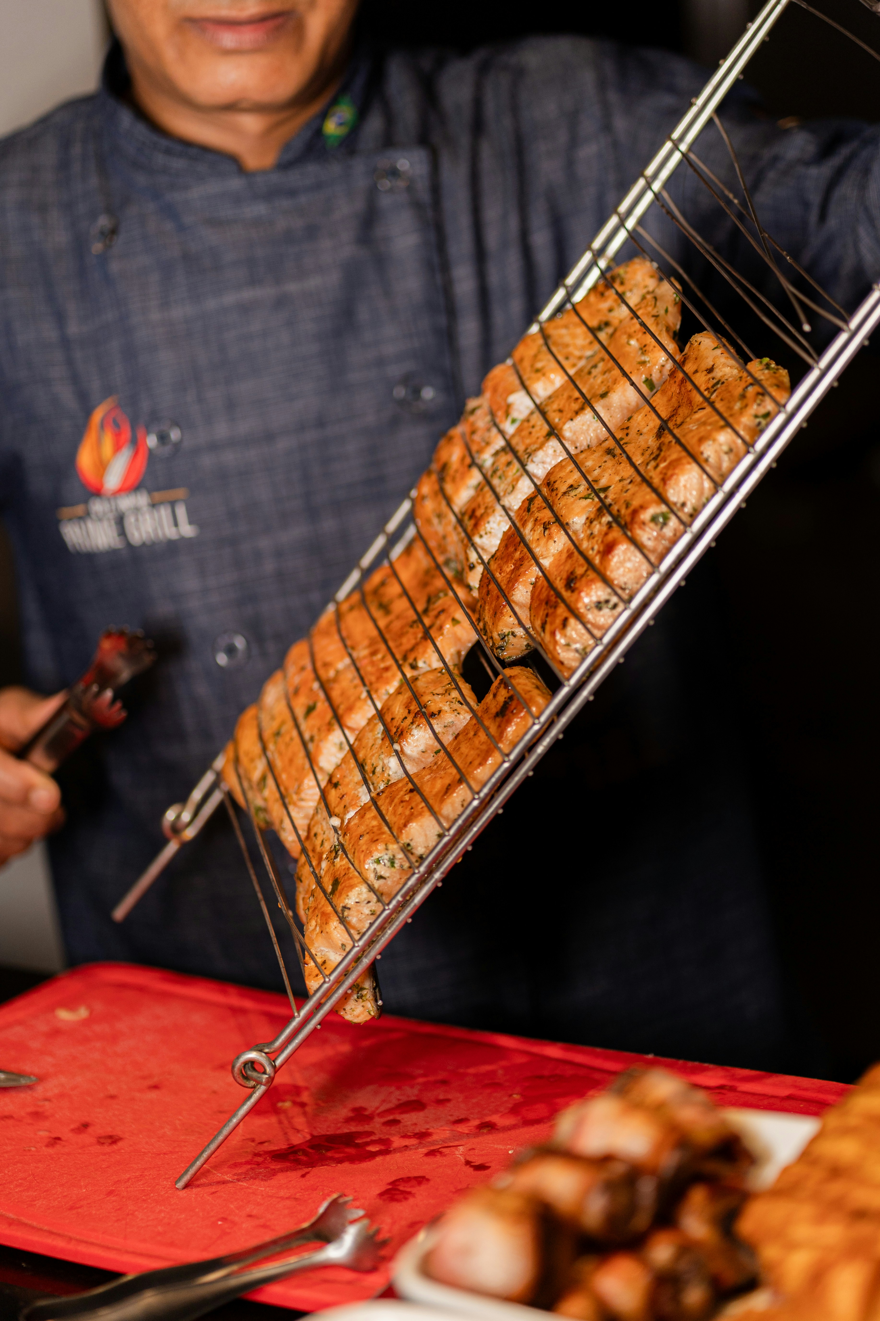 A chef holds grilled meat in a cage. photo – Free Food Image on Unsplash