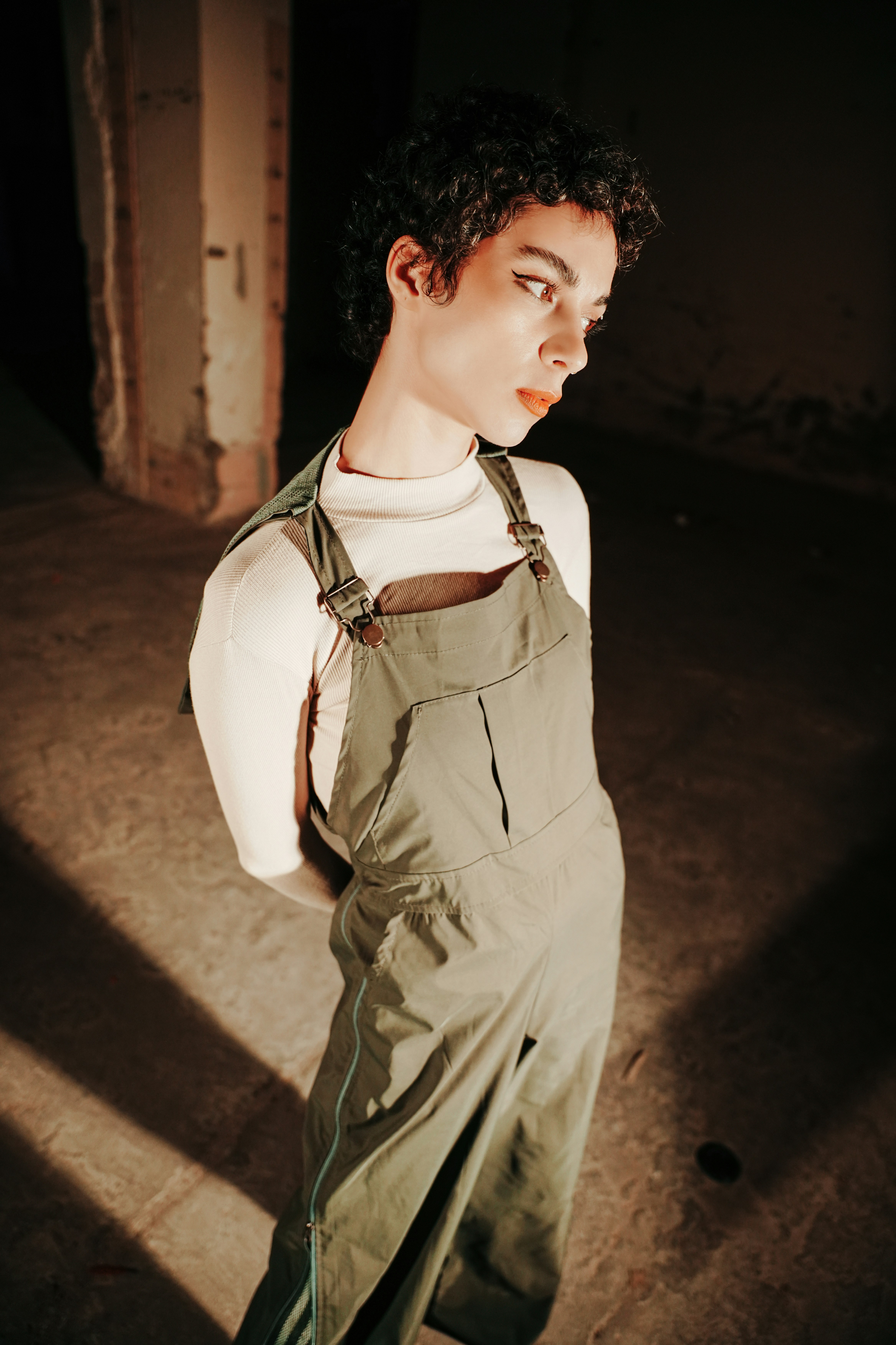 Warm Spotlight on a Solitary Figure in Olive Overalls