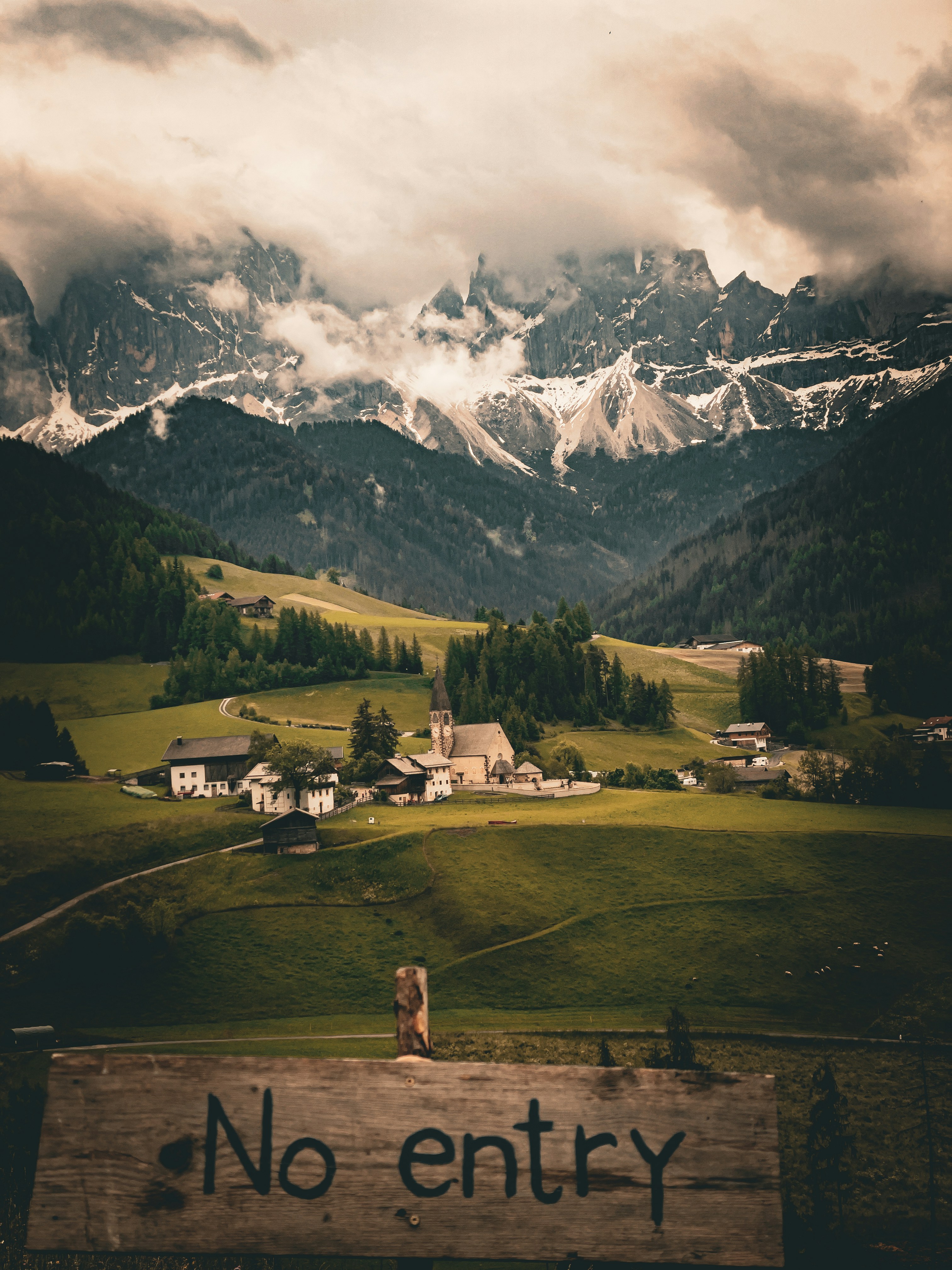 Alpine Quietude: A Valley Village Beneath Cloud-Shrouded Peaks