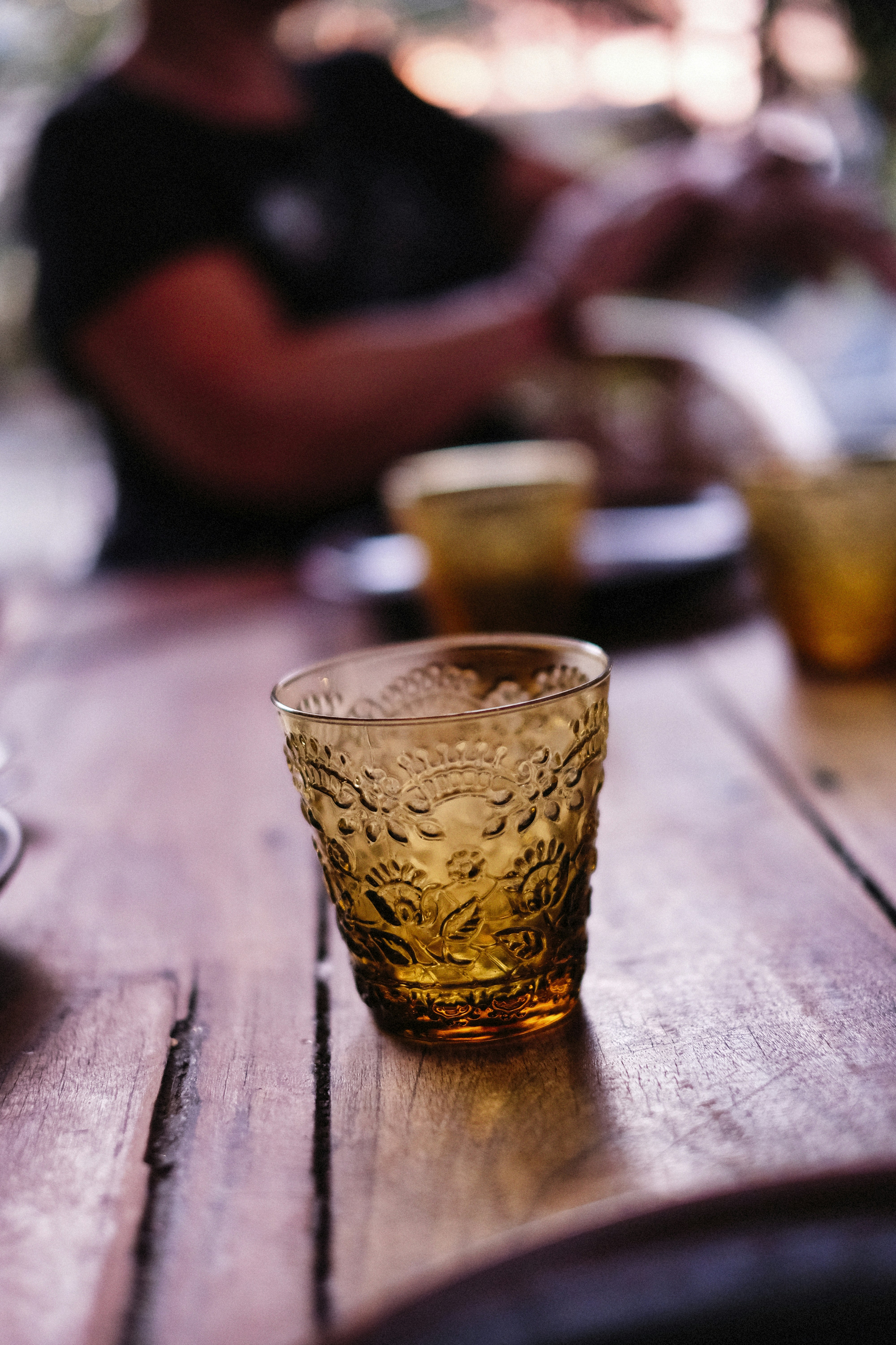 Golden glasses sit on a rustic wooden table.