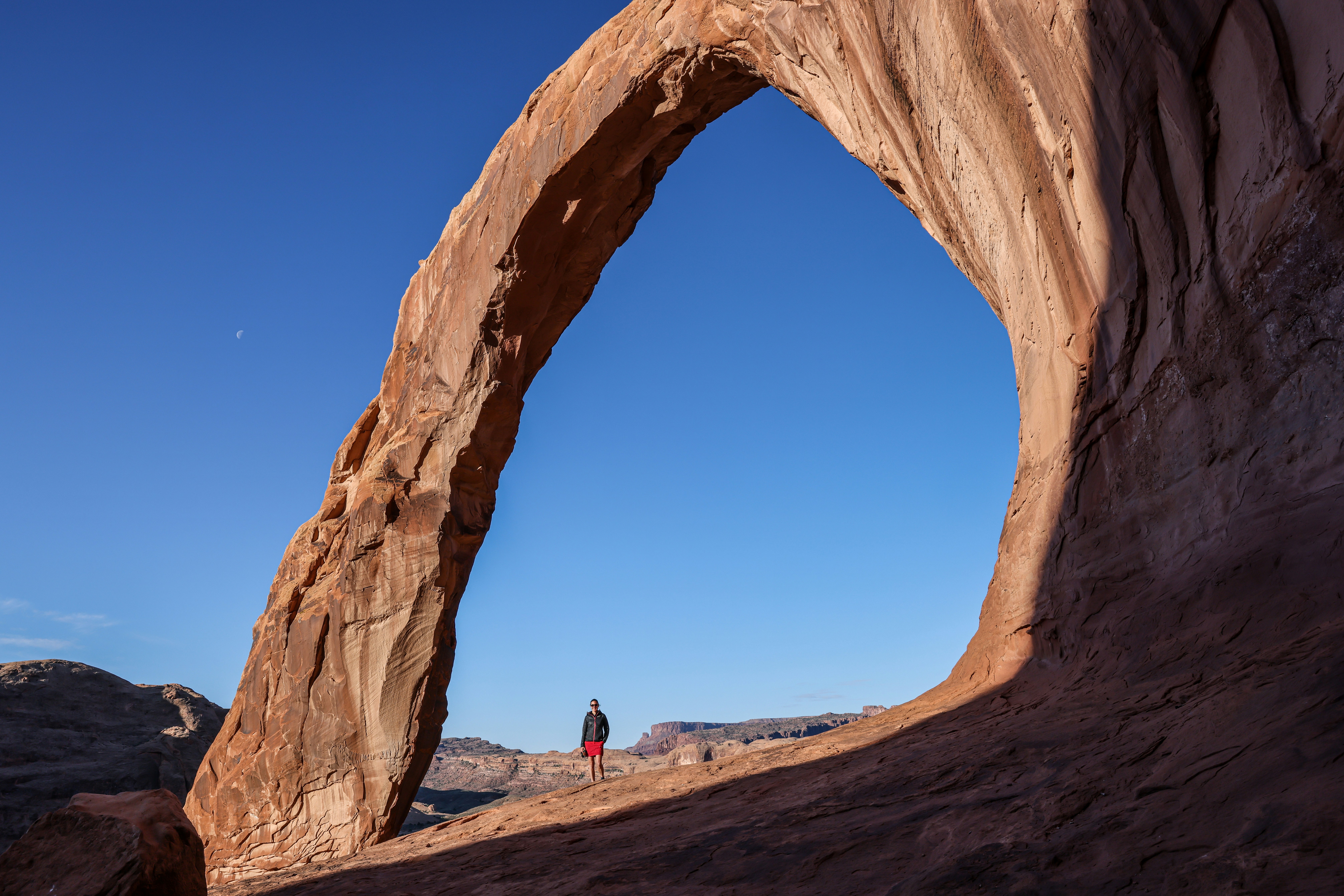 A person stands beneath a majestic arch. photo – Free Utah Image on ...