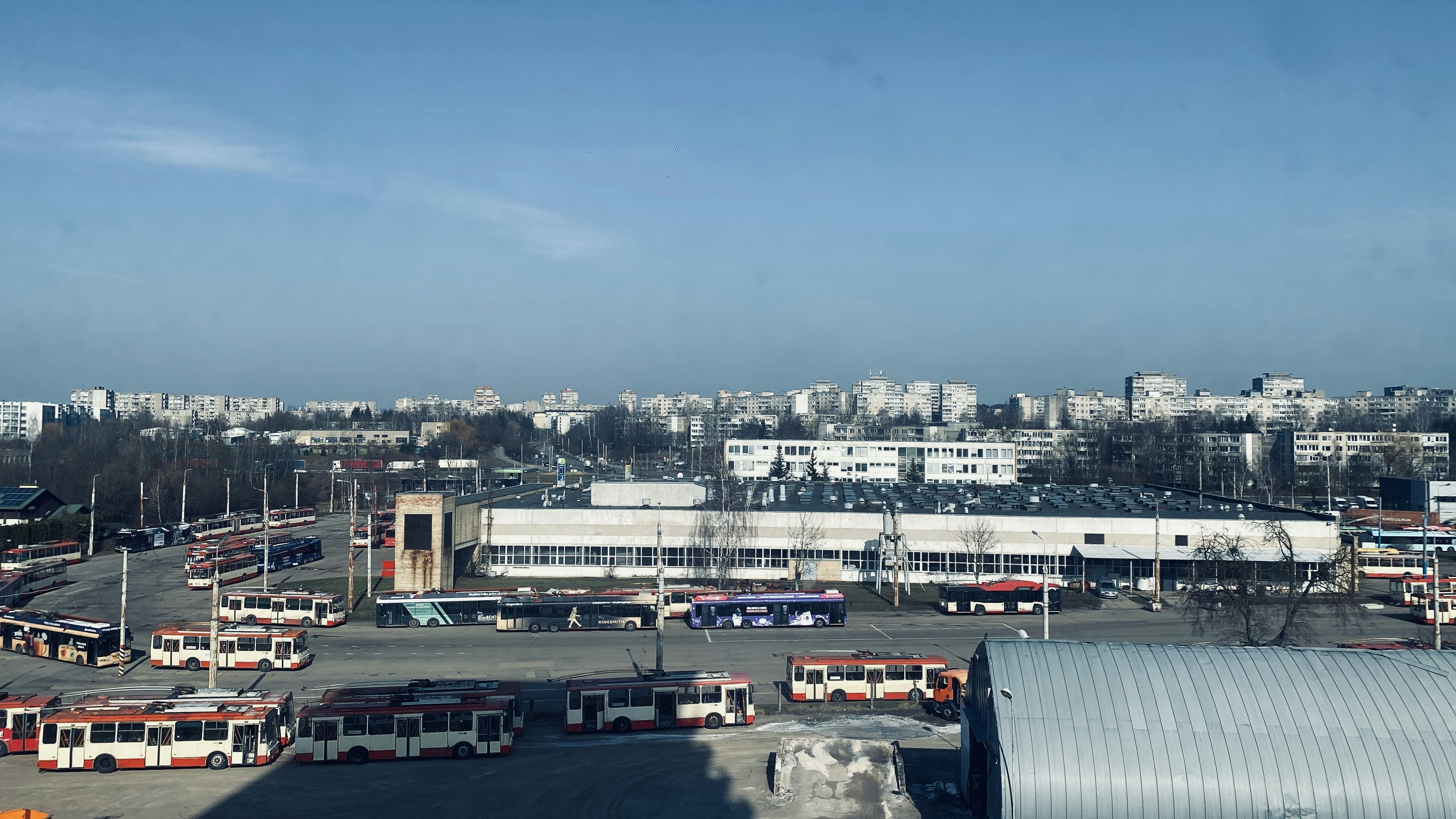 Buses parked in a large city bus station.