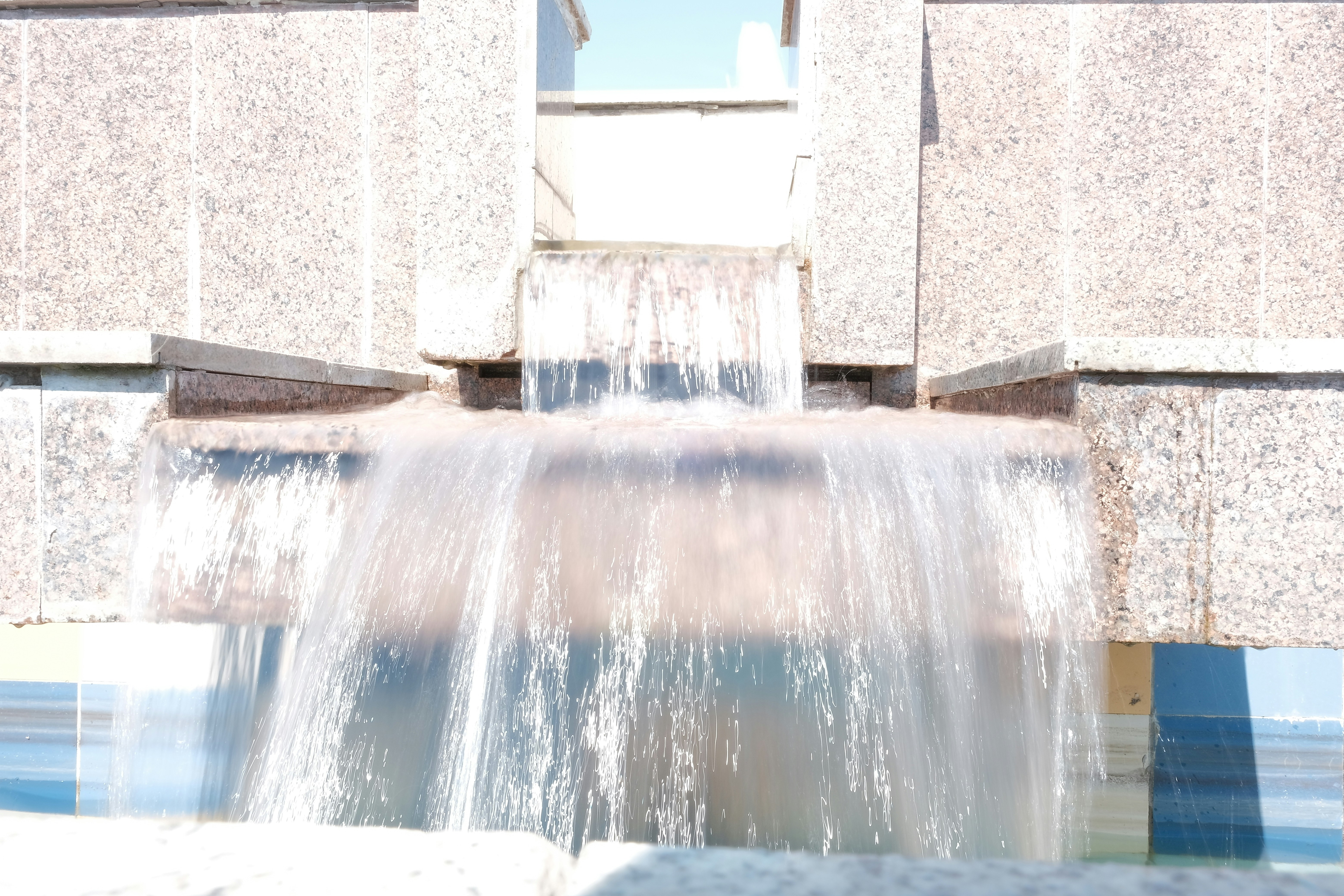 A close-up of cascading water flowing over a stone structure, creating a serene and dynamic scene.