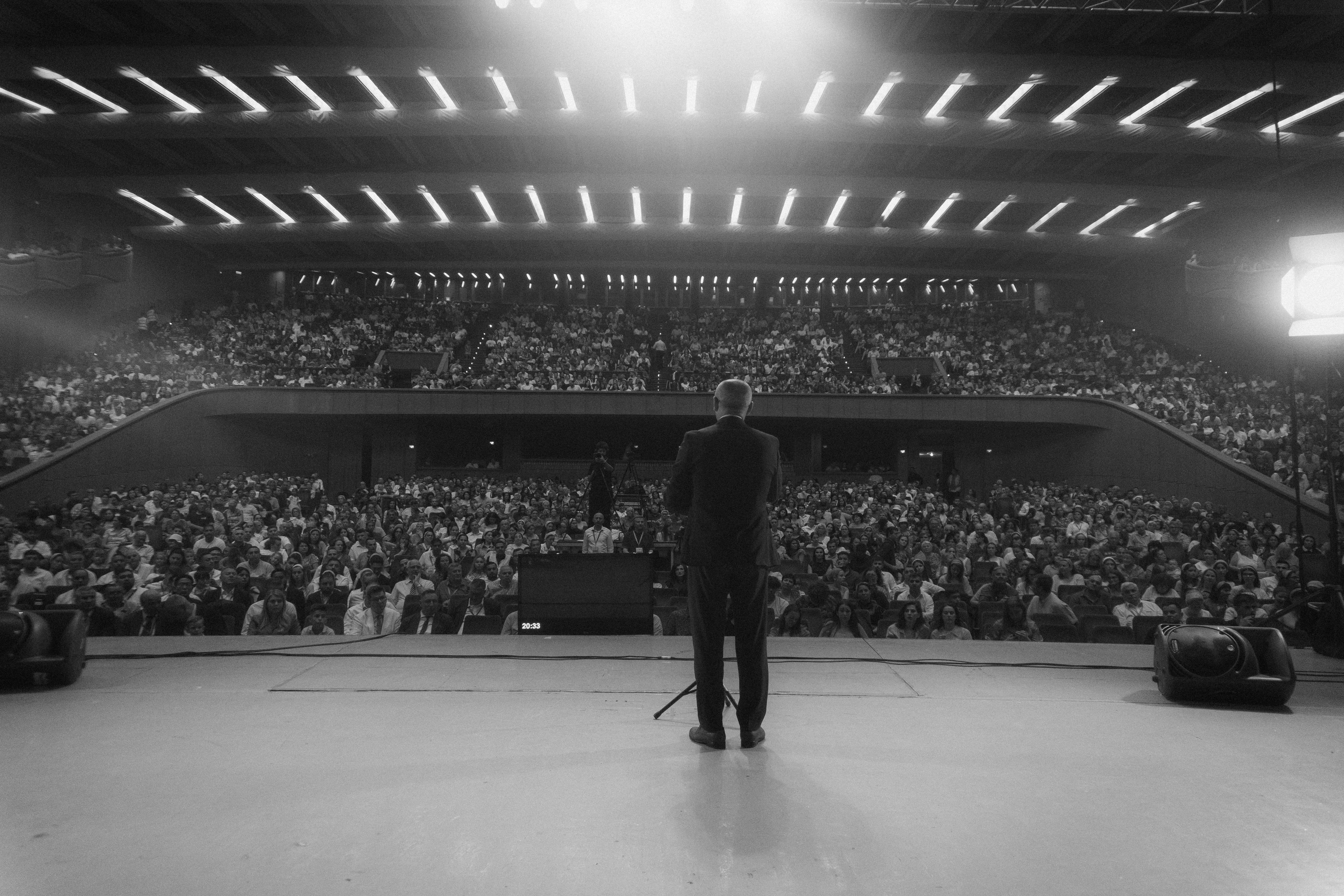 A speaker addresses a large, packed audience. photo – Free Event Image ...