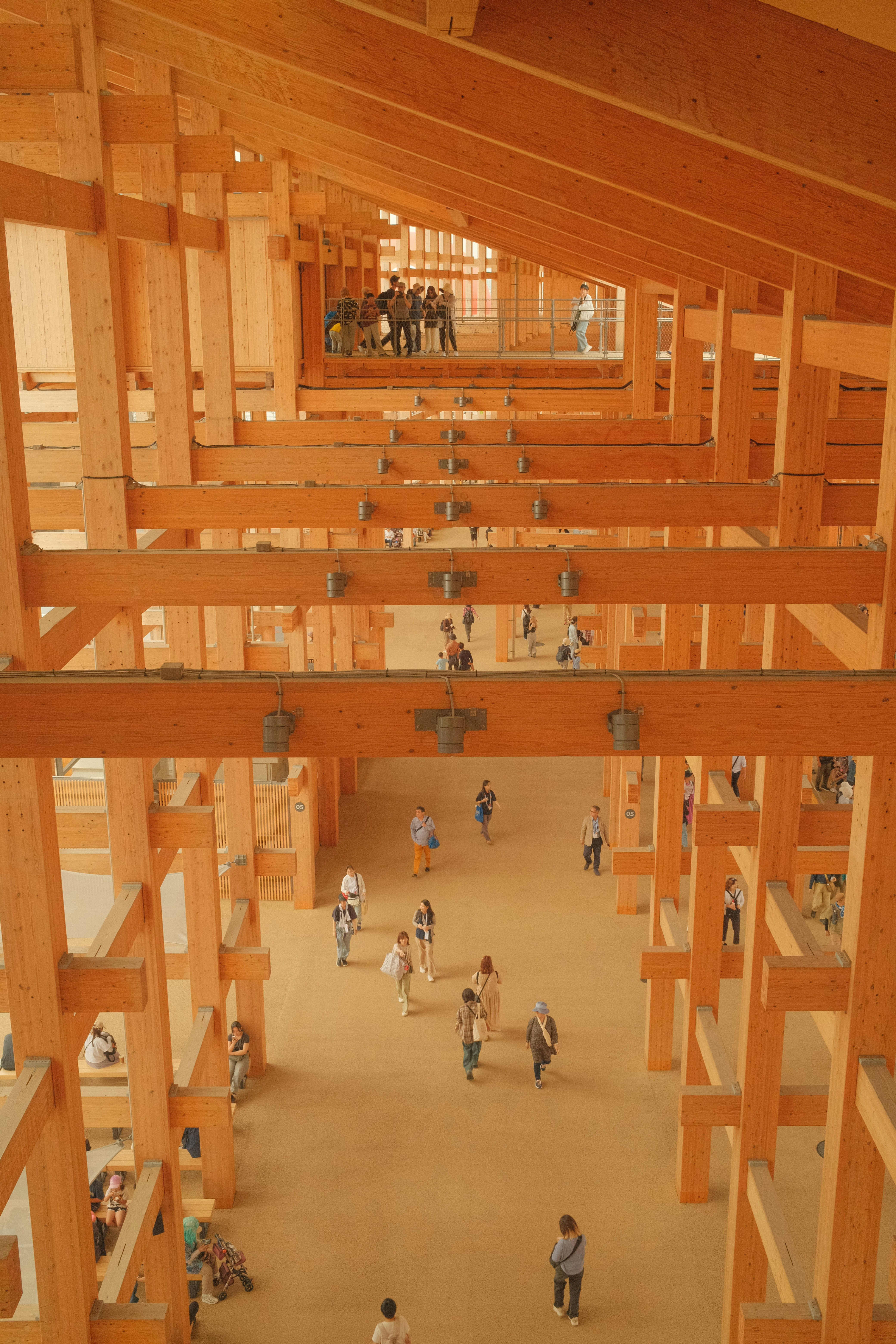Timber Cathedral: People Walk the Intersecting Beams of a Grand Atrium