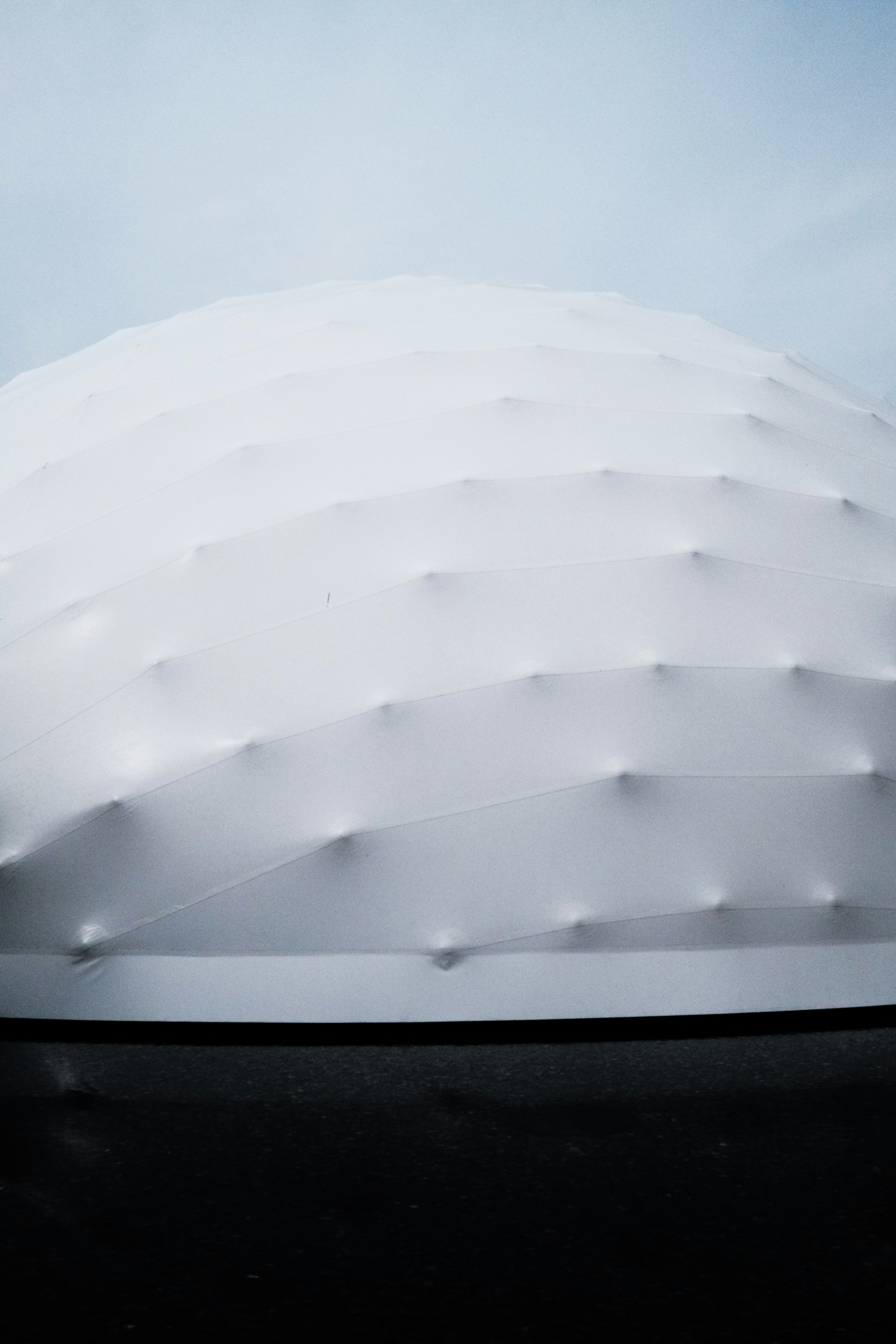 Quilted Dome: a soft-geometry sculpture under a pale blue sky