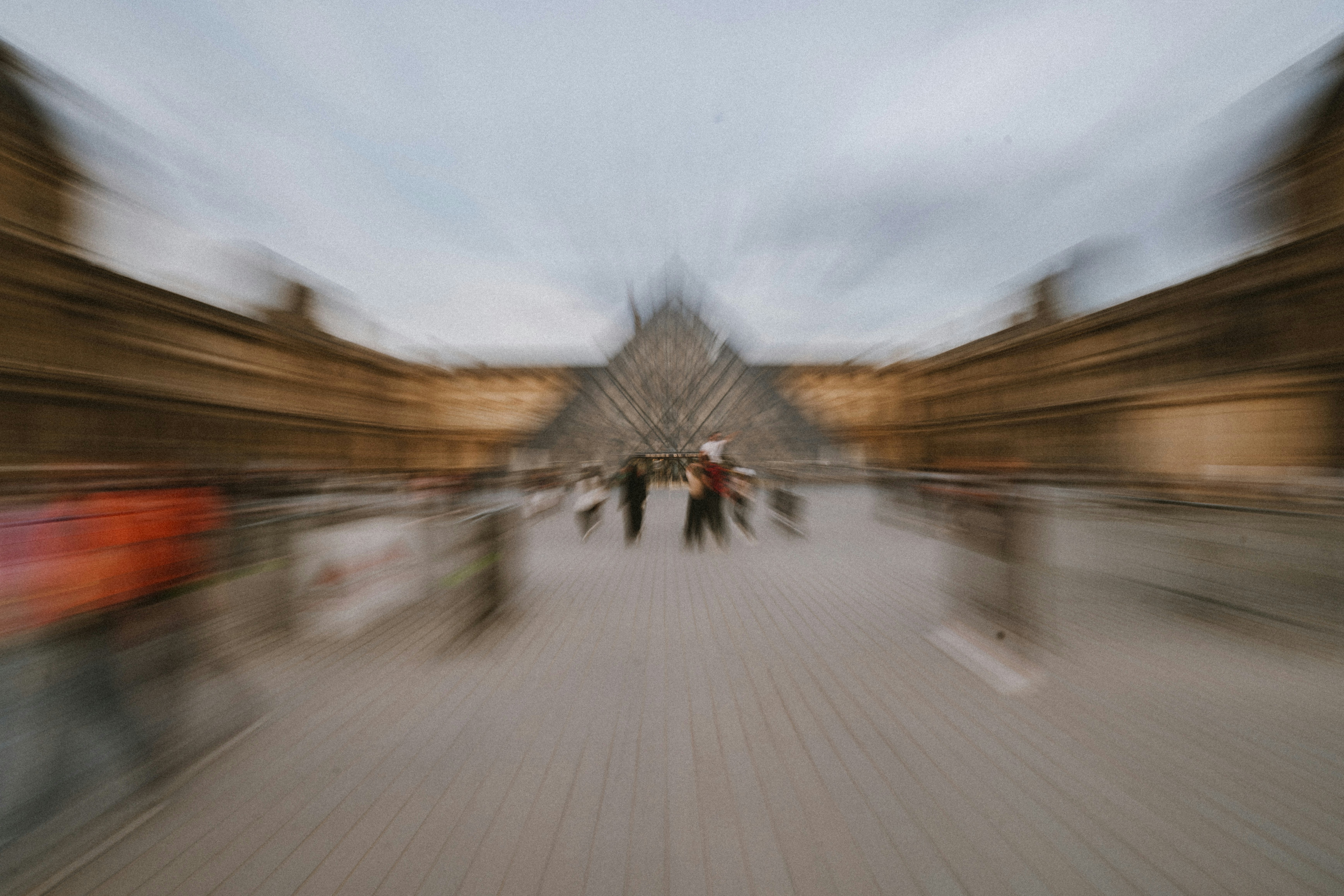 People walk near the louvre pyramid.