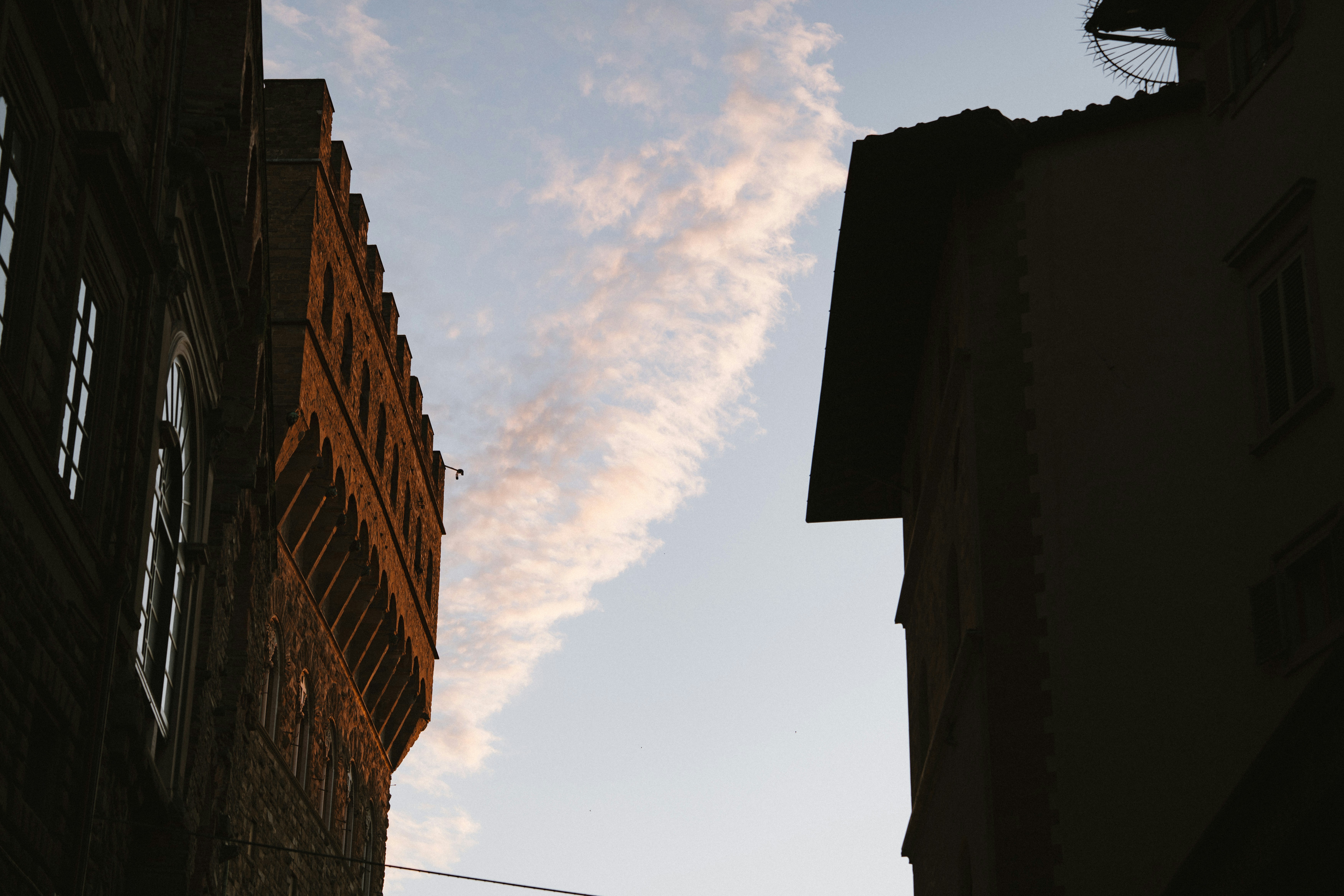 Buildings frame the sky with streaky clouds.