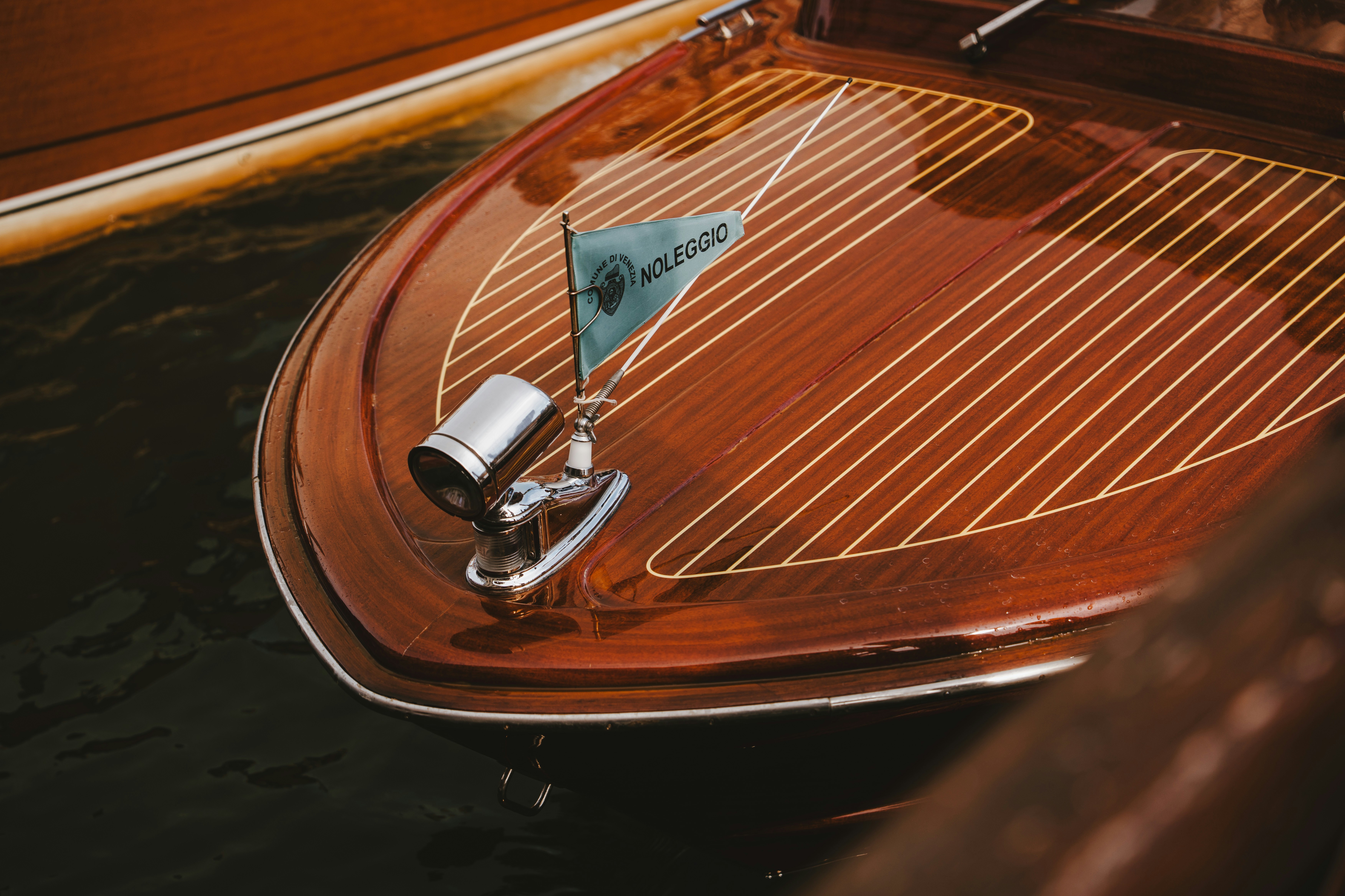 NOLEGGIO Flag on a Polished Wooden Bow in a Quiet Marina
