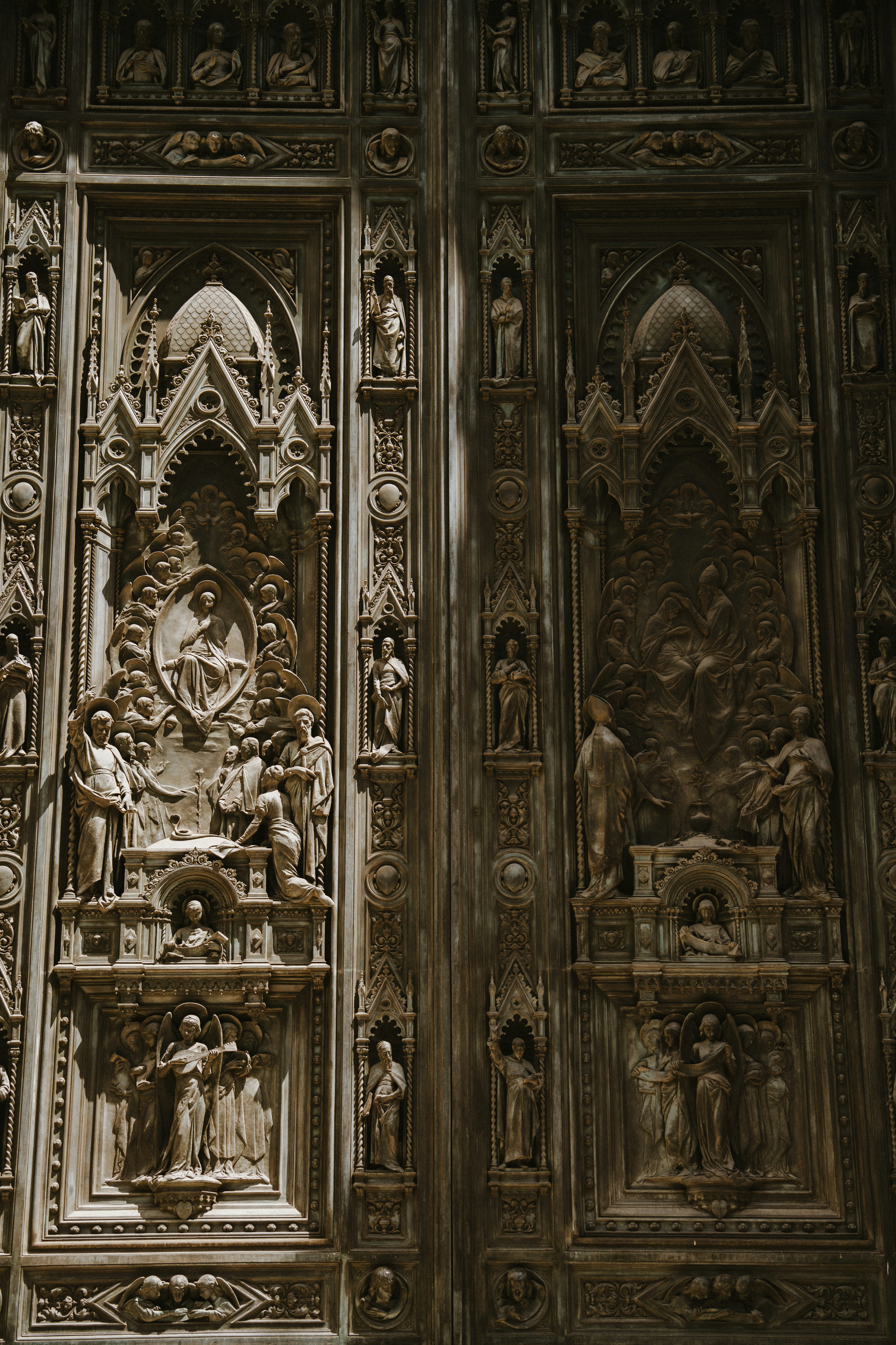 Ornate stone carvings depicting religious figures and scenes, showcasing exquisite craftsmanship and detail. The relief artwork highlights the artistry of the period.