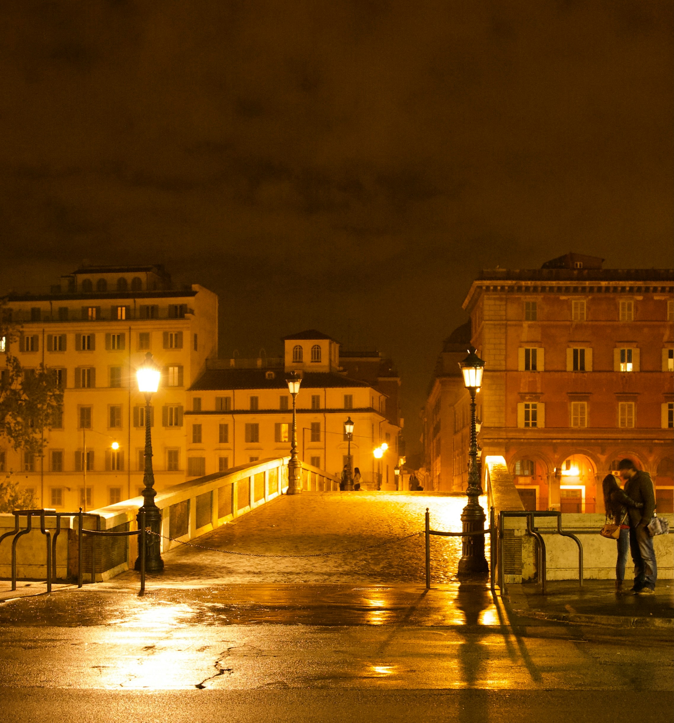 Nighttime bridge view with kissing couple in Trastevere, Rome. 2015 I didn’t know much about digital cameras and was trying to frame the bridge/juggle the high ISO while wearing glasses. I didn’t see the couple until I got the pic on a PC.
