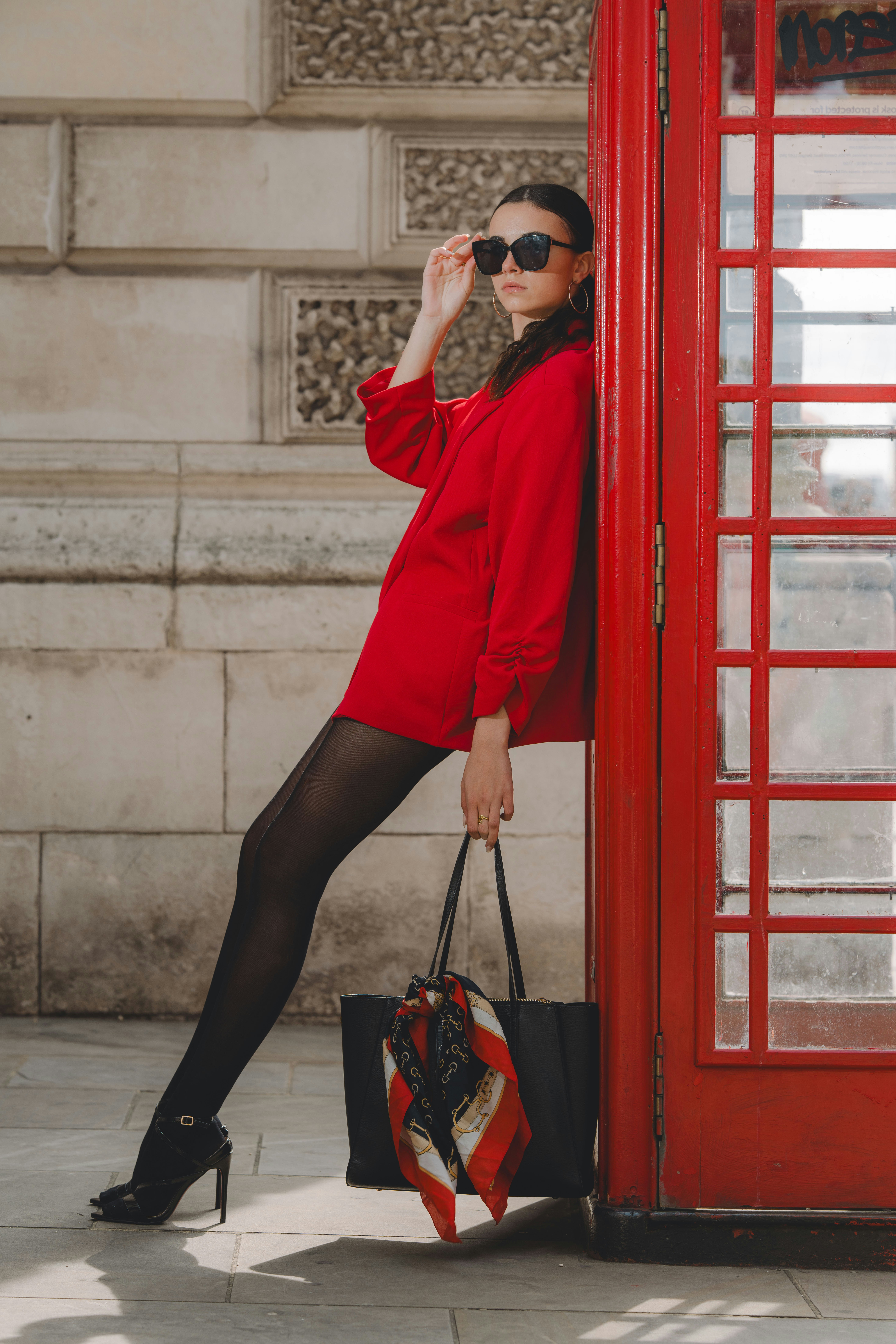 Woman in red outfit poses by a red telephone booth. photo – Free Female ...