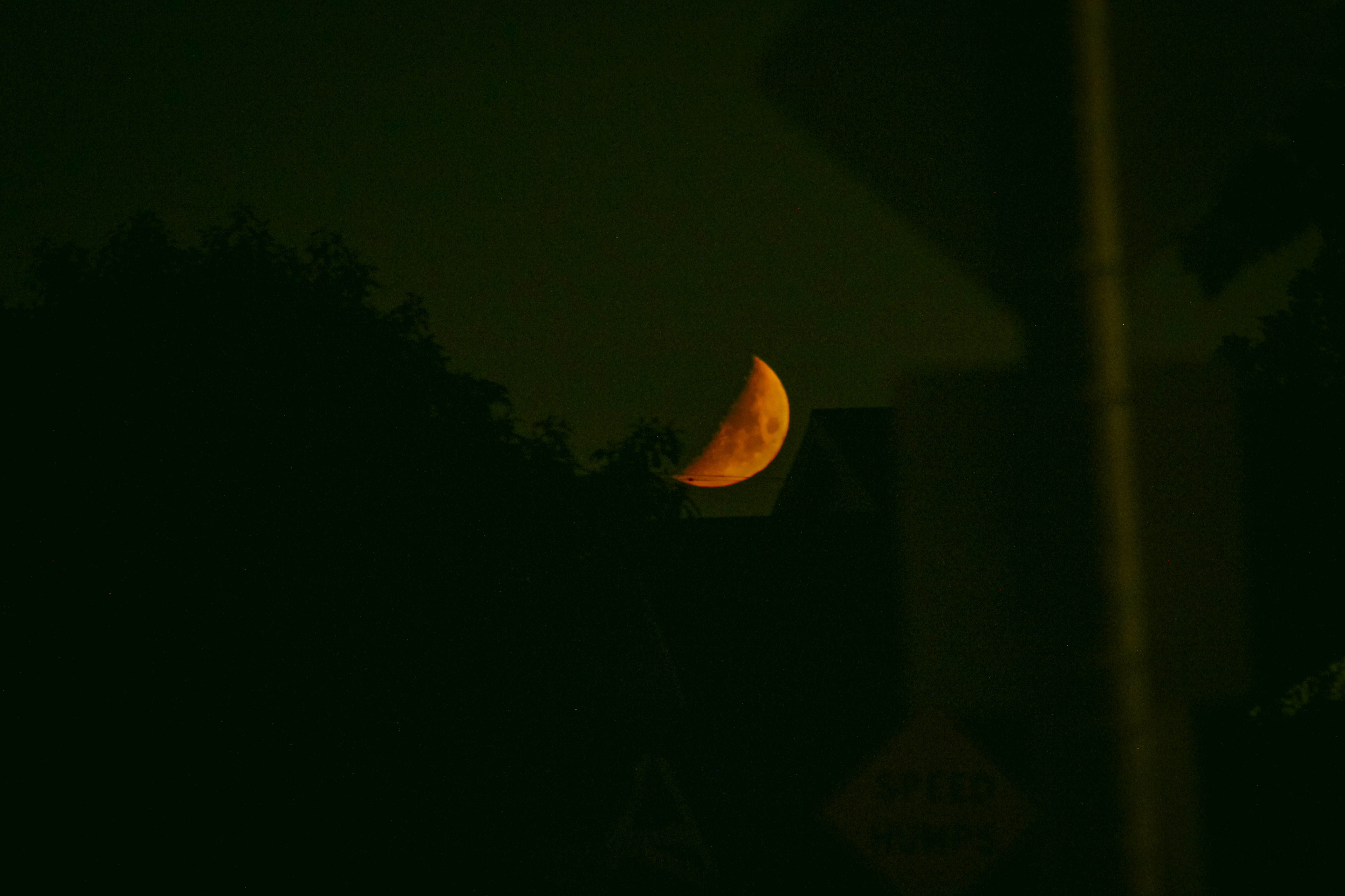 moon | A crimson crescent moon shines against the dark.