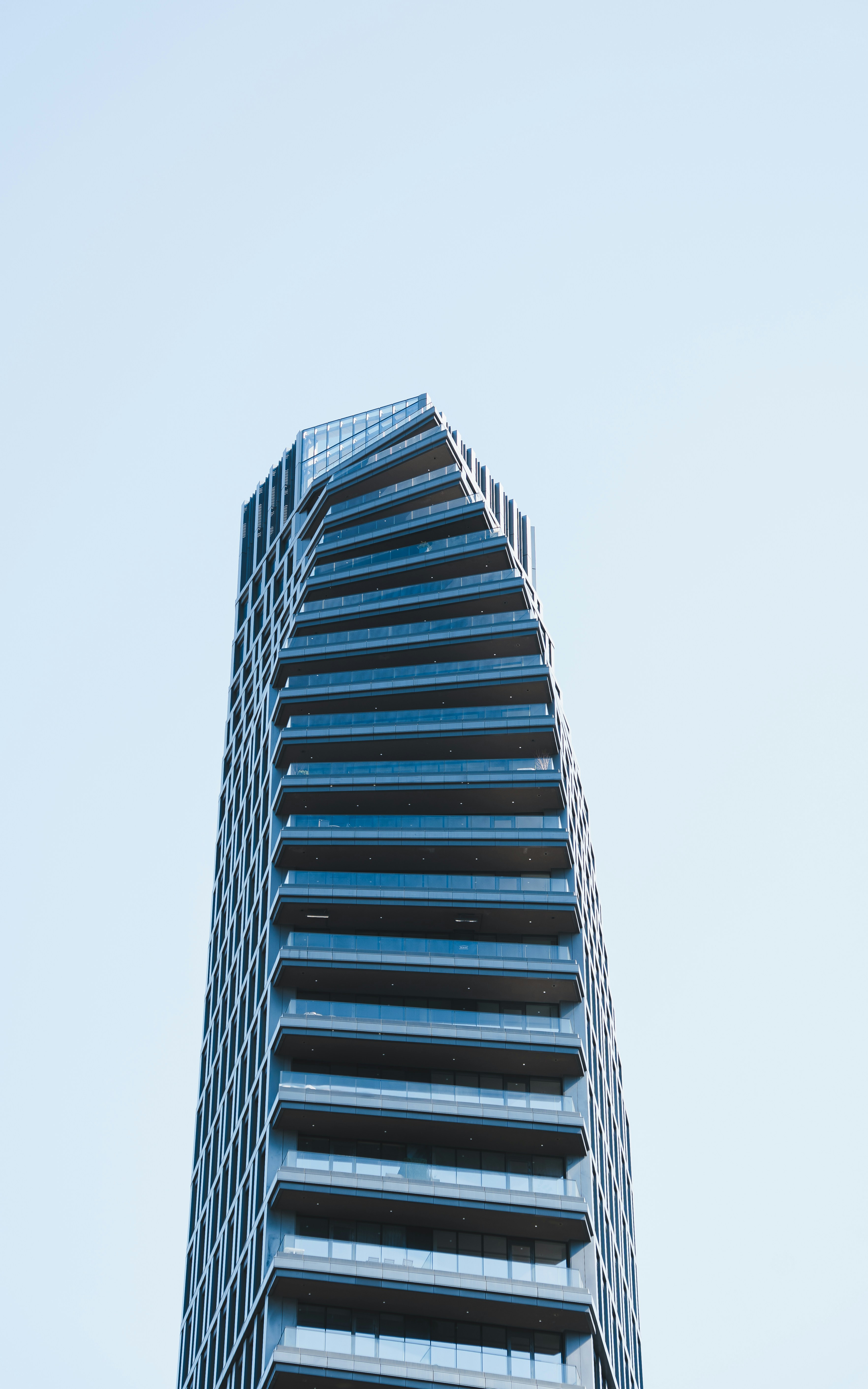 A sleek, modern skyscraper with a distinctive zigzag design, reaching towards a clear blue sky.