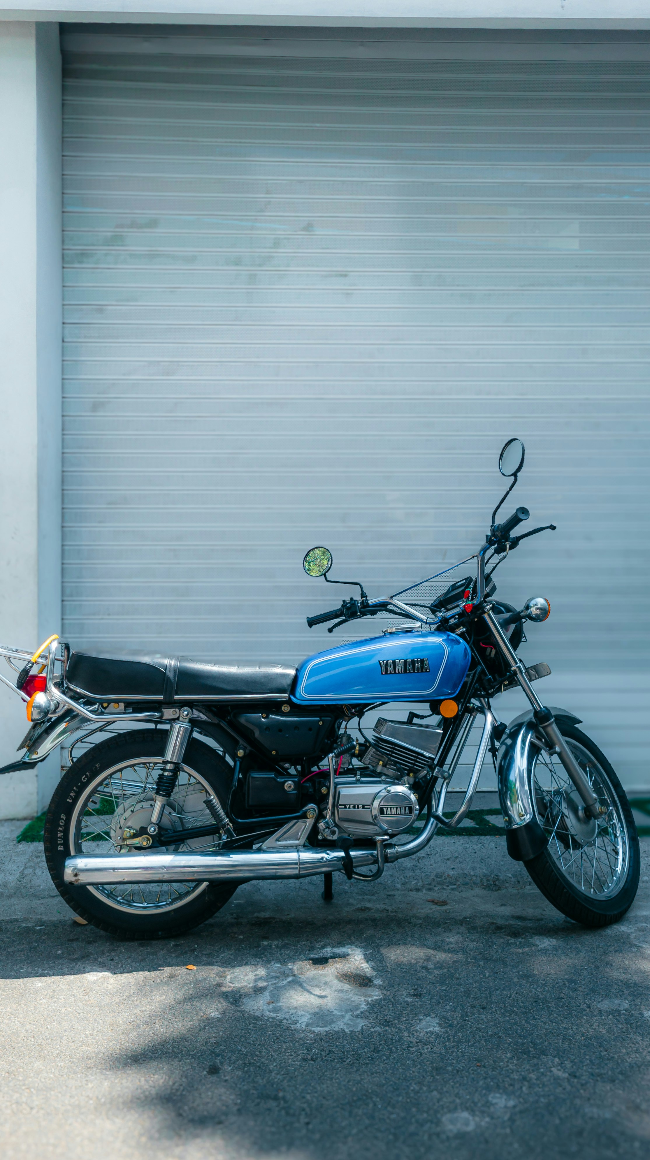 A classic Yamaha motorcycle parked against a neutral backdrop, showcasing its sleek design and chrome details.
