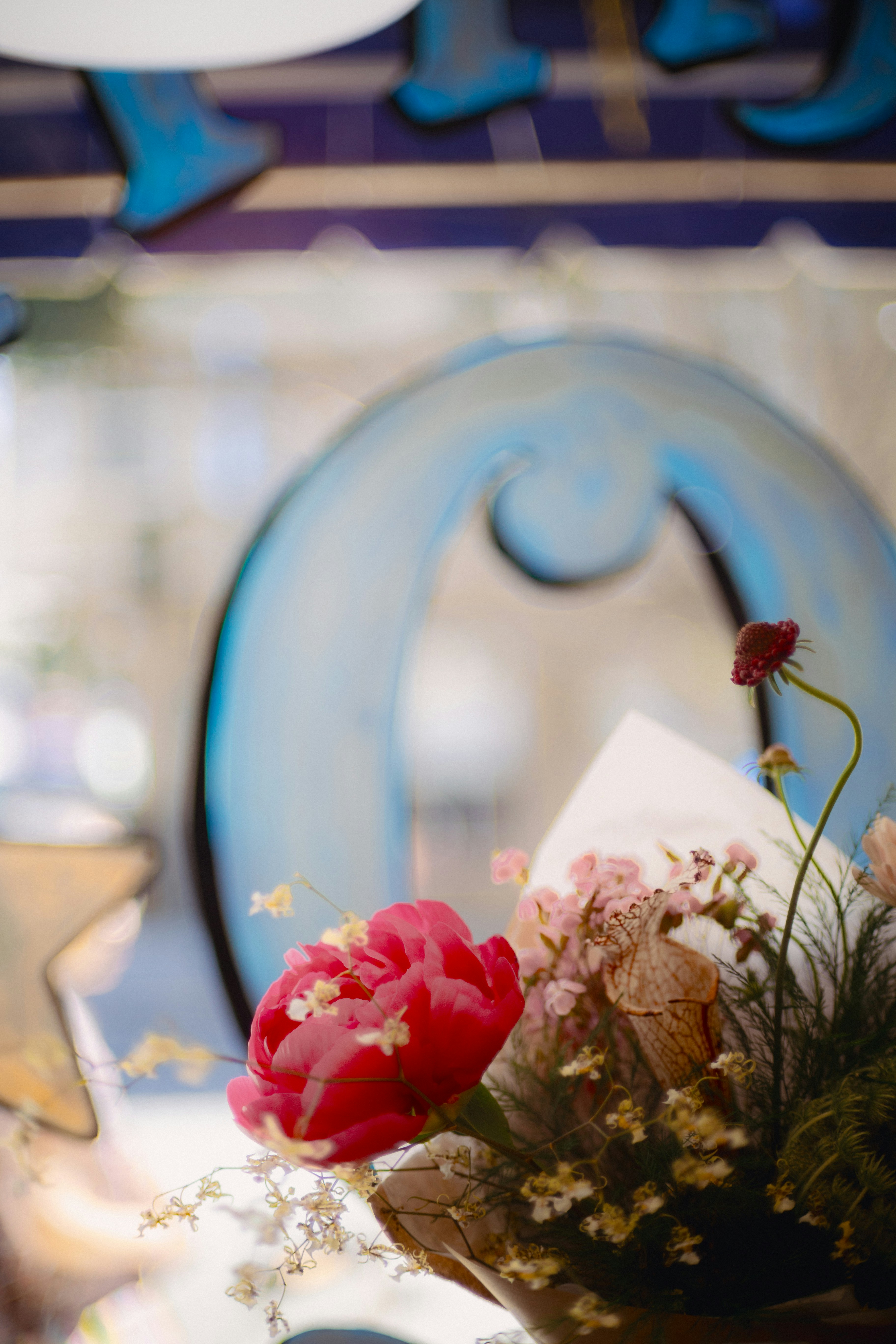 Bouquet in Focus Before the Neon Oval