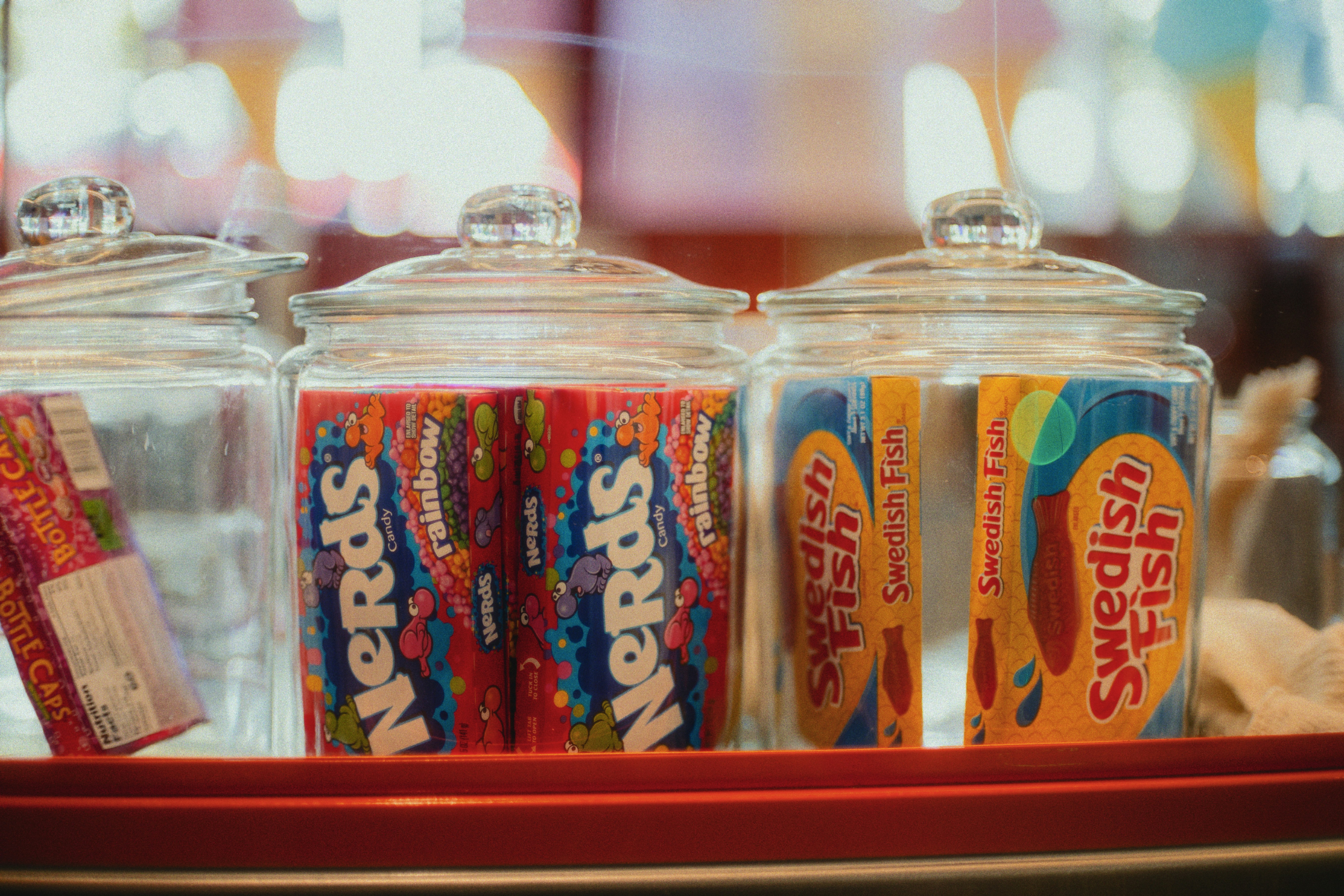 Candy jars filled with nerds and swedish fish.