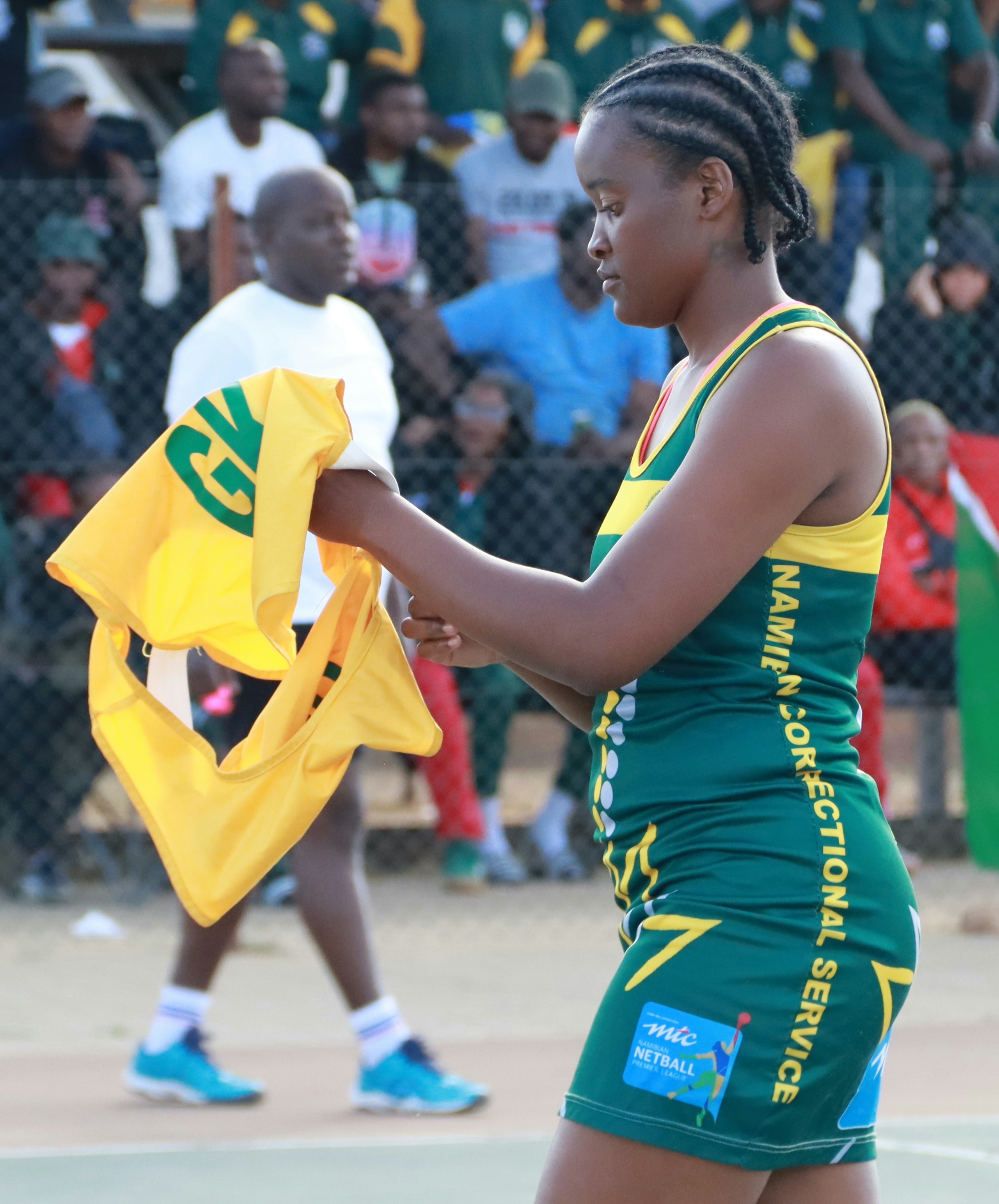 A netball player holds her bib during the game. photo – Free Woman ...
