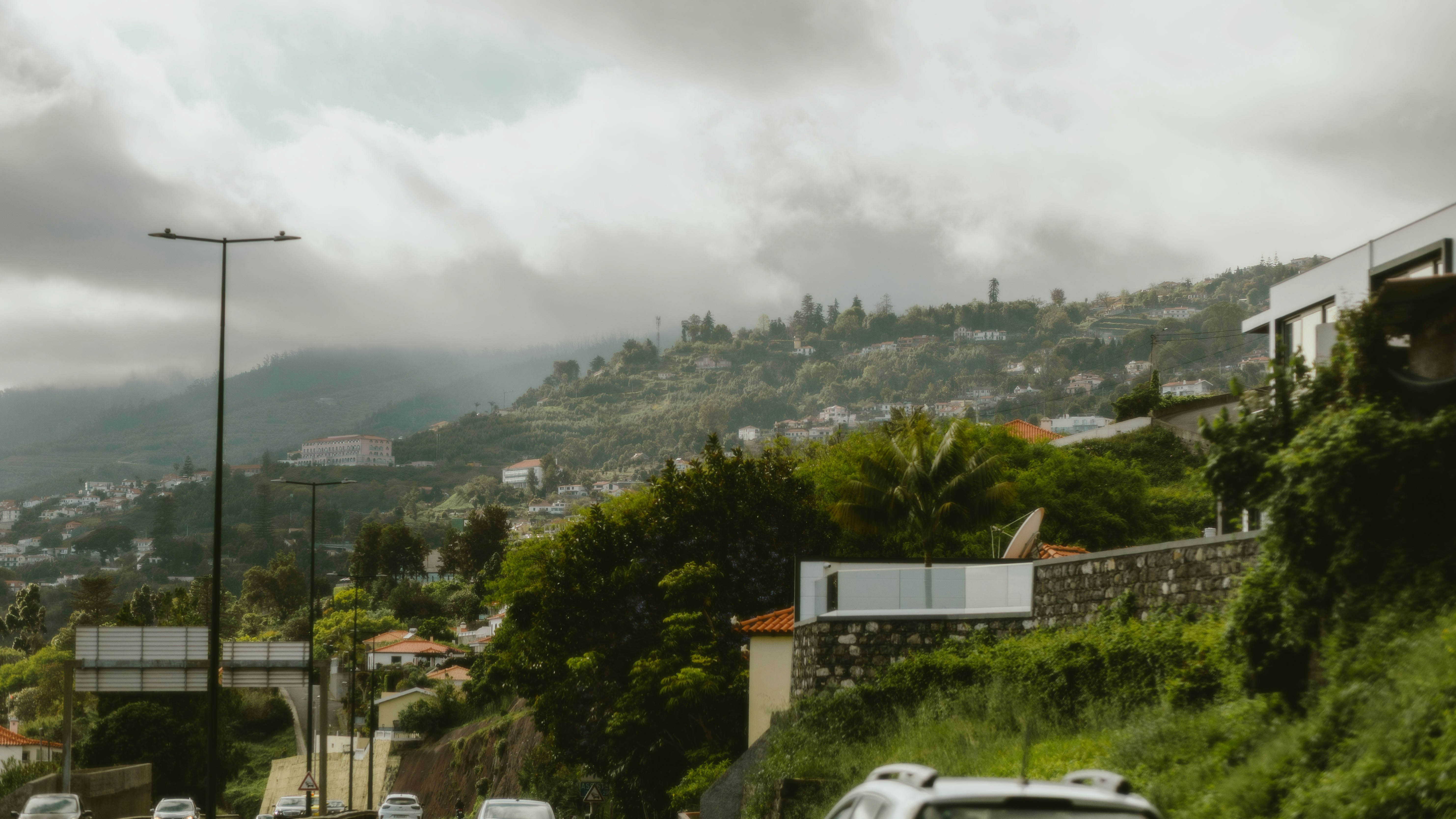 Lone Streetlamp Framing a Cloud-Wreathed Hillside Village