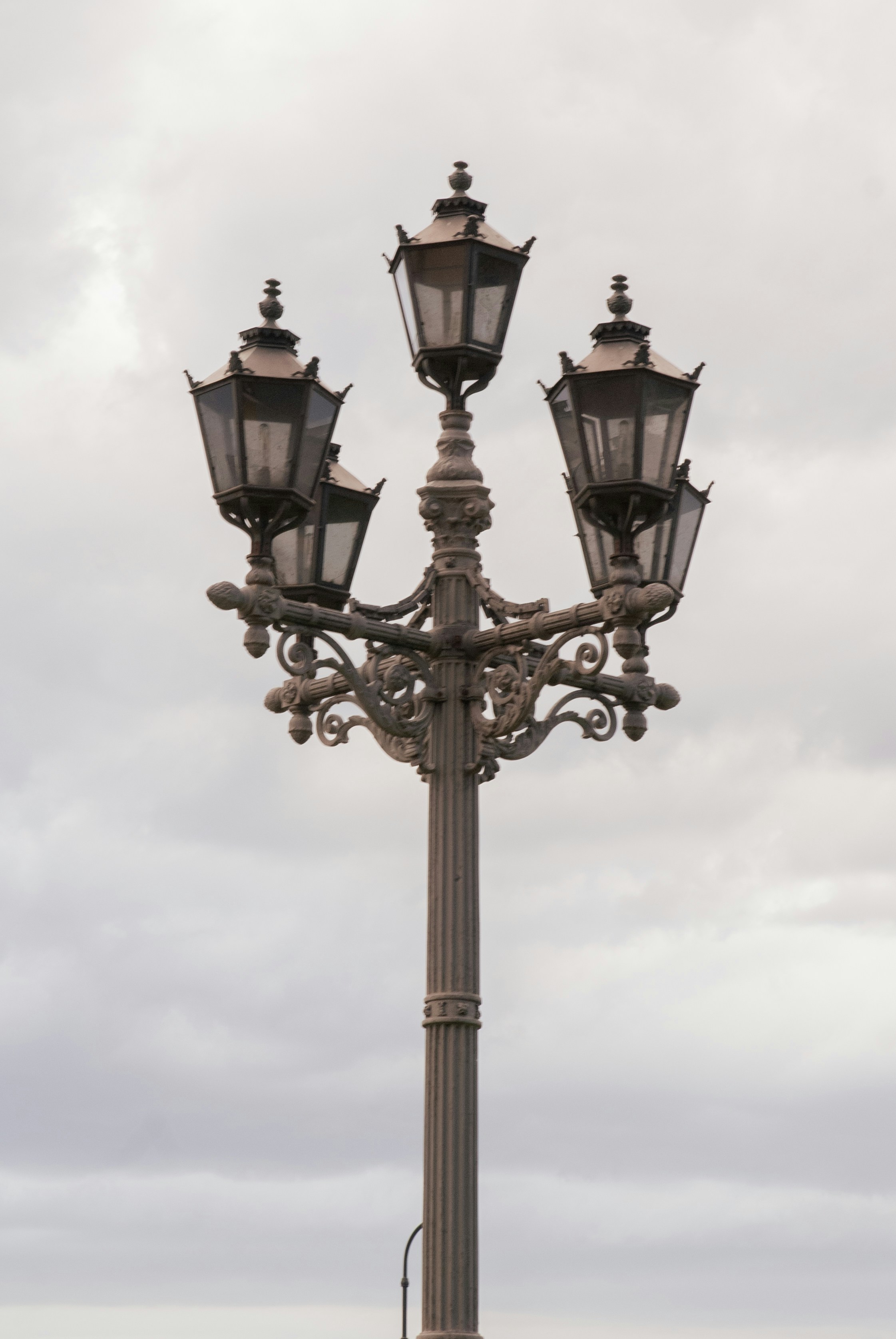 SONY DSC | An ornate lamp post stands against a cloudy sky.