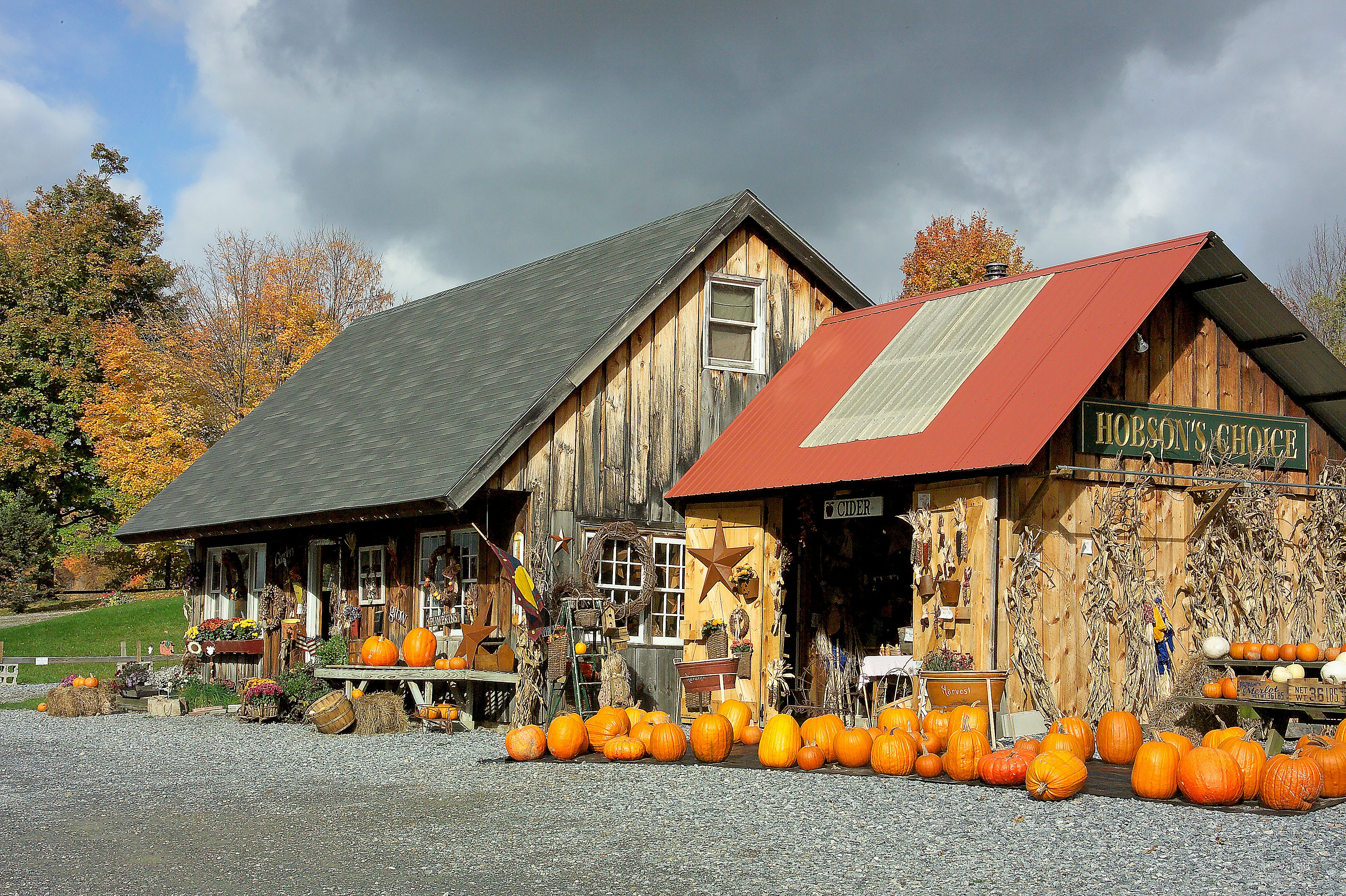 A farmer's roadside stand is stocked and ready for the fall festivities. | Pumpkins and a farm stand in autumn.