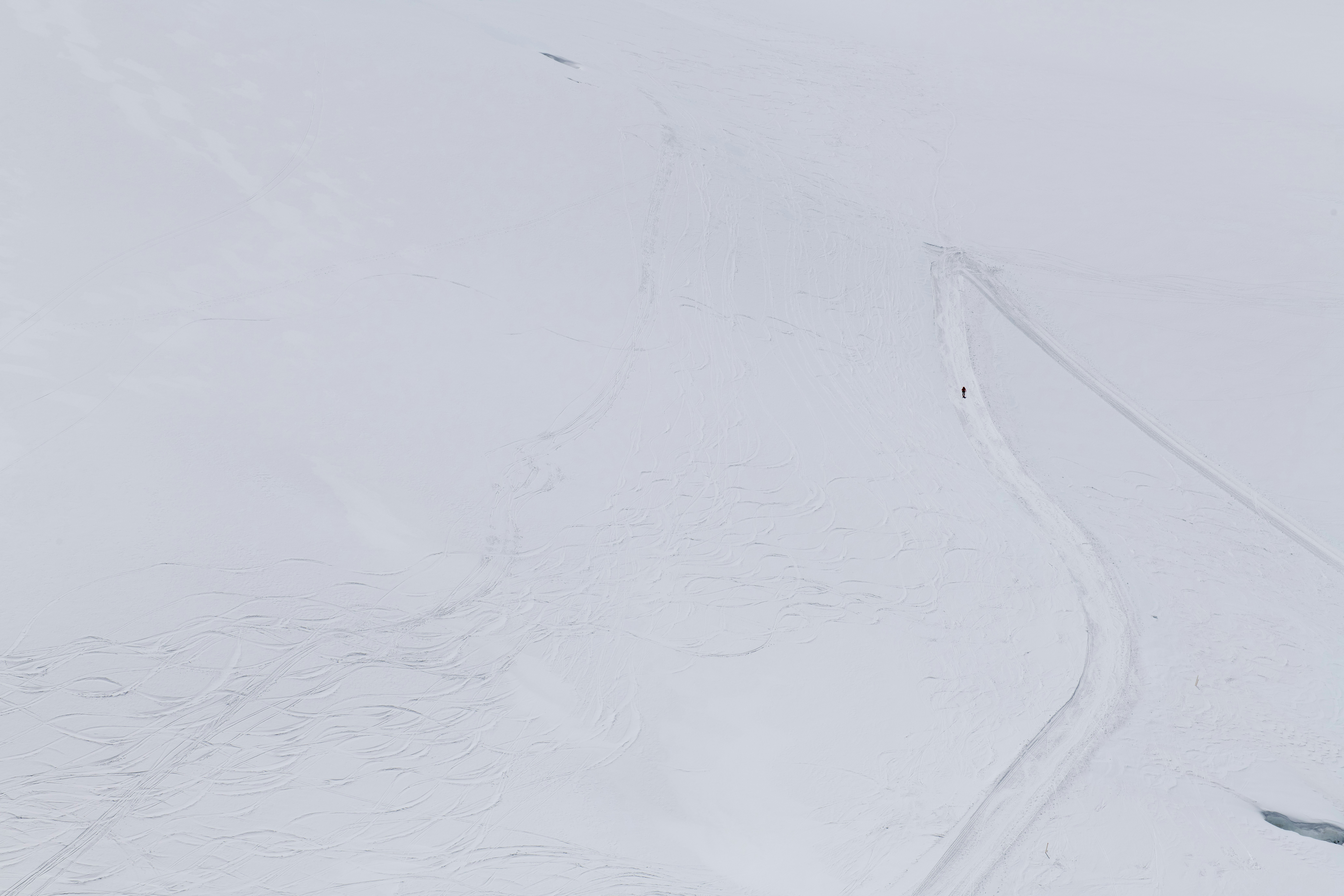 A snowy landscape features a skier descending a slope. photo – Free ...