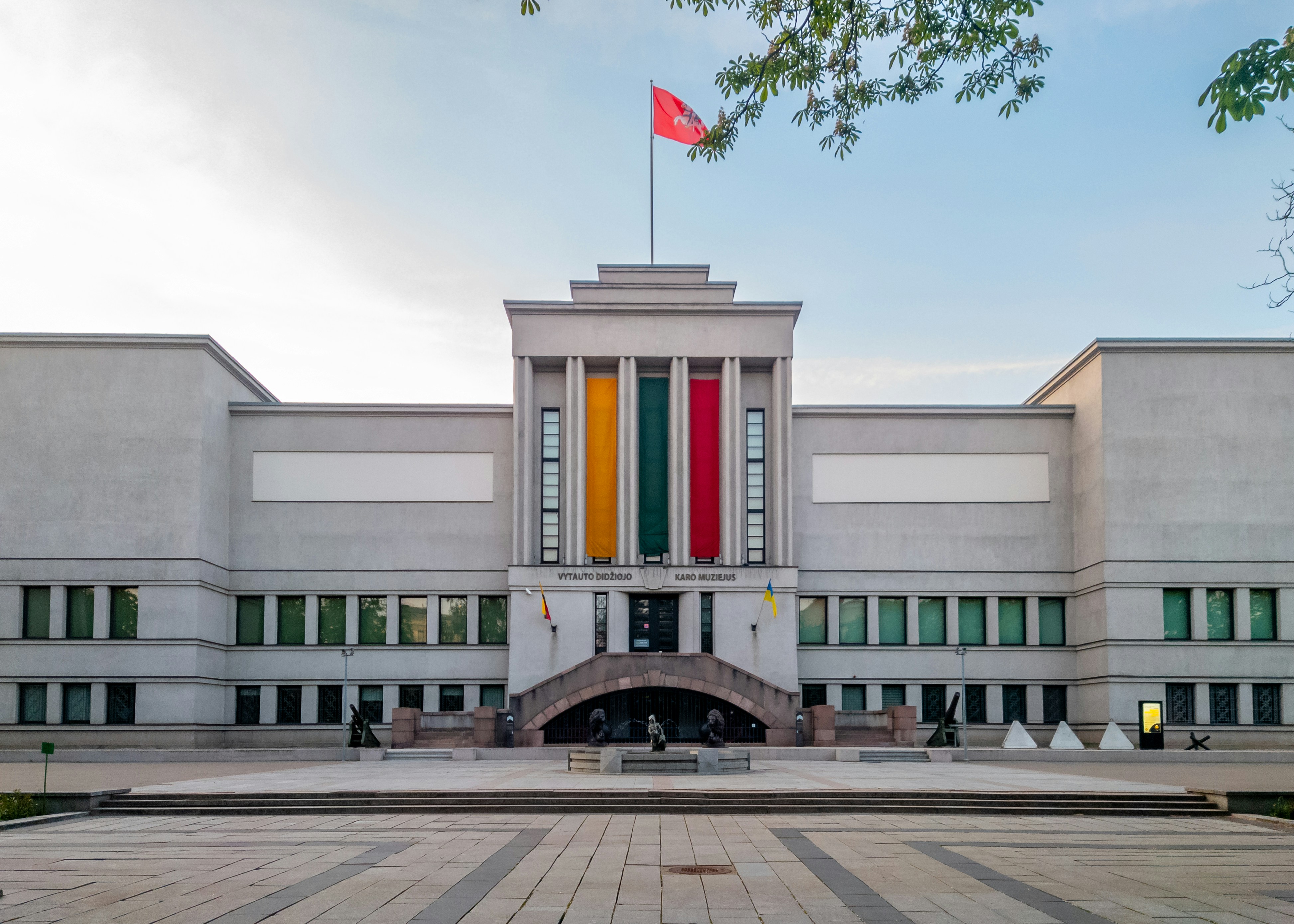 Modern government building adorned with national flags, showcasing a blend of contemporary design and patriotic symbolism.
