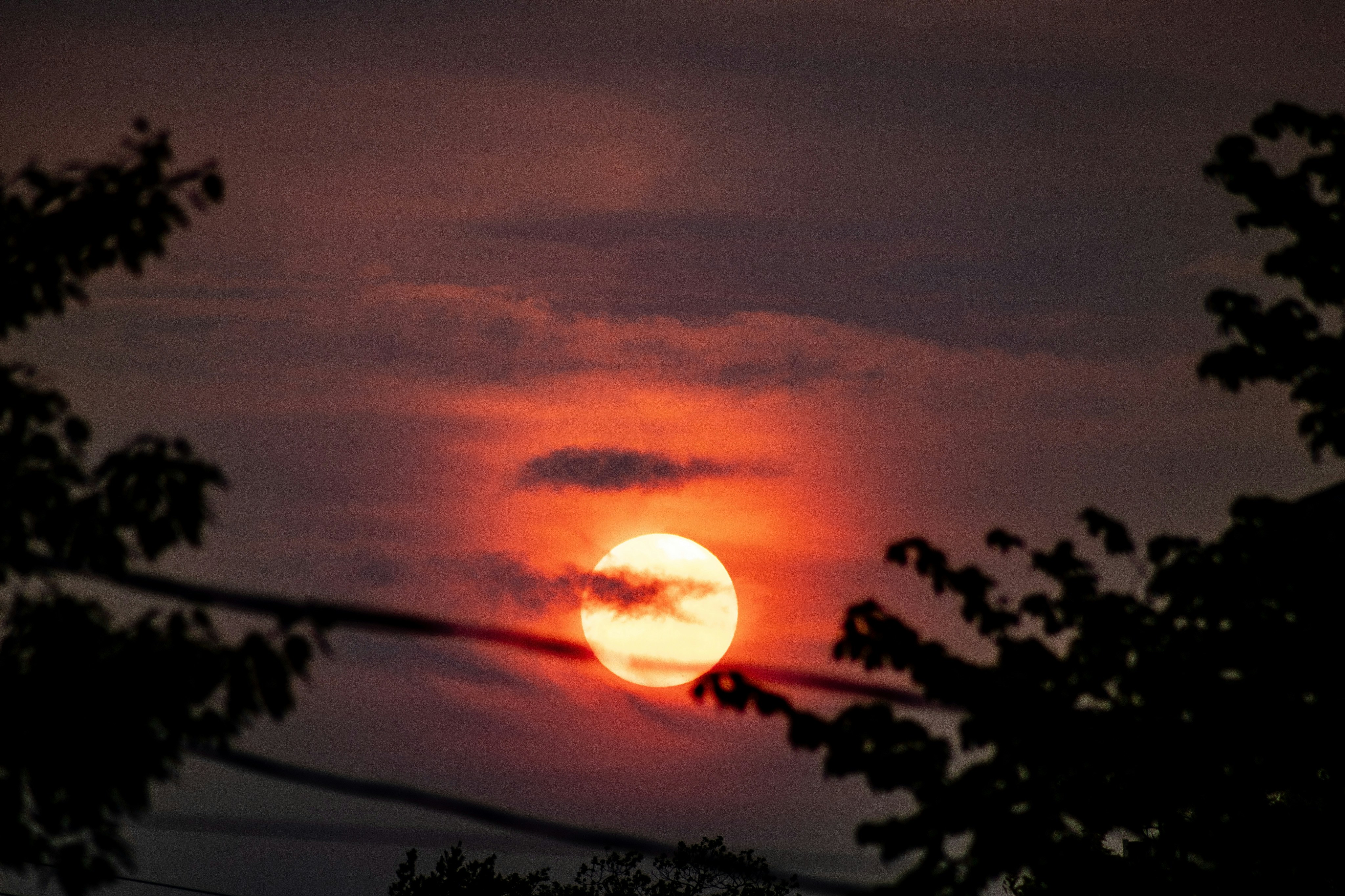The red sun sets, casting a beautiful sunset.