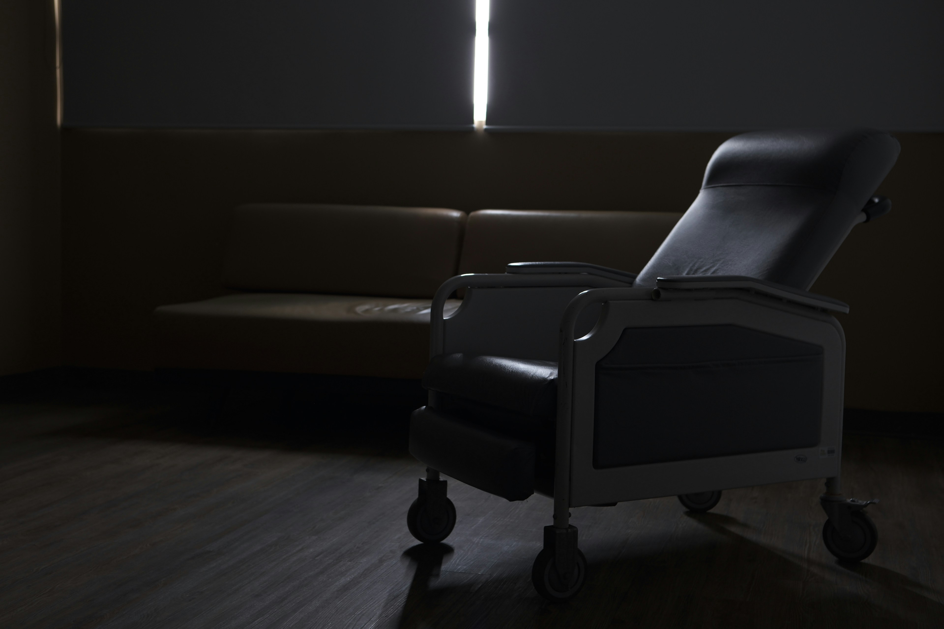 A darkened room with a chair is shown. photo – Free Image on Unsplash