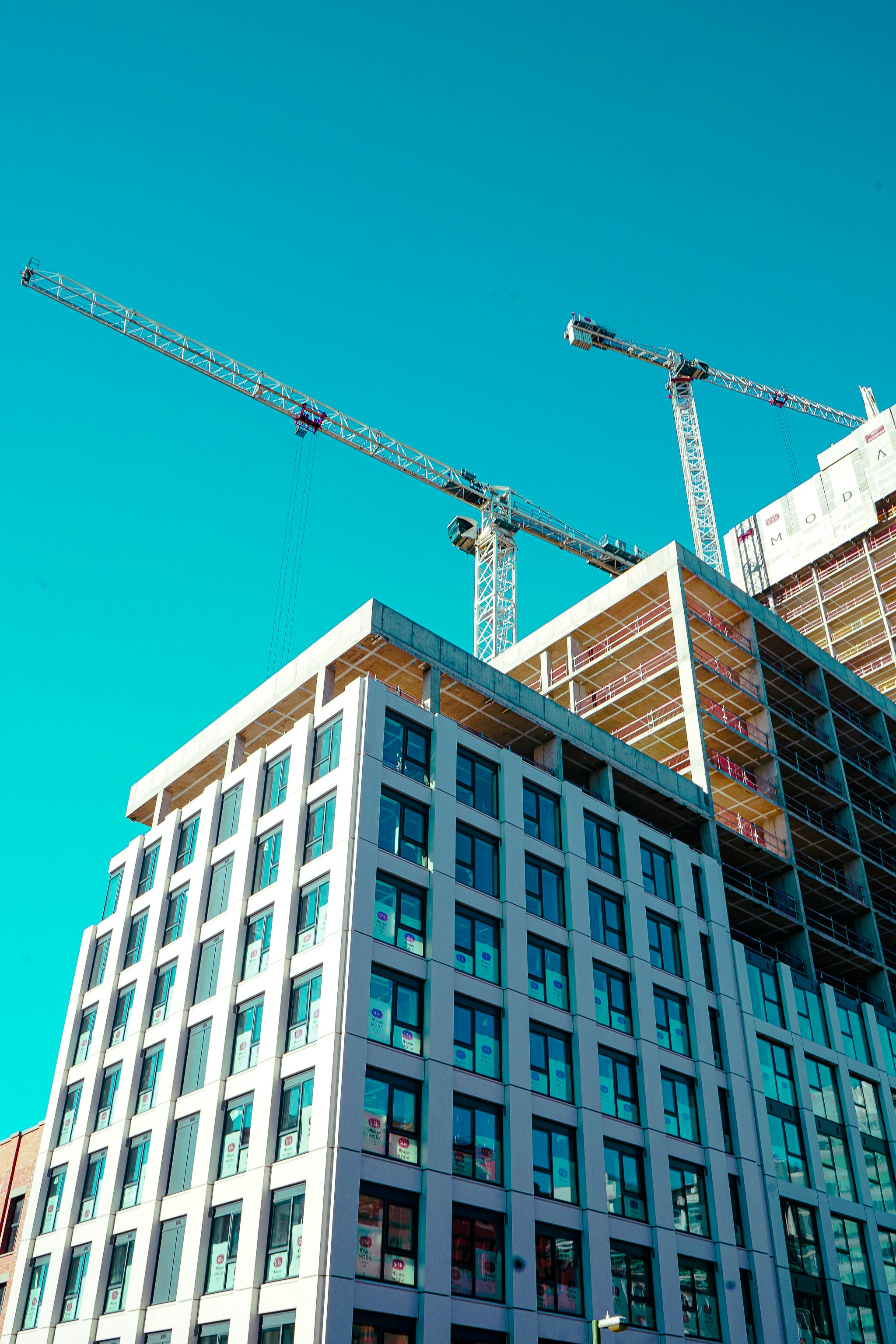 Construction cranes work on a building's exterior. photo – Free ...