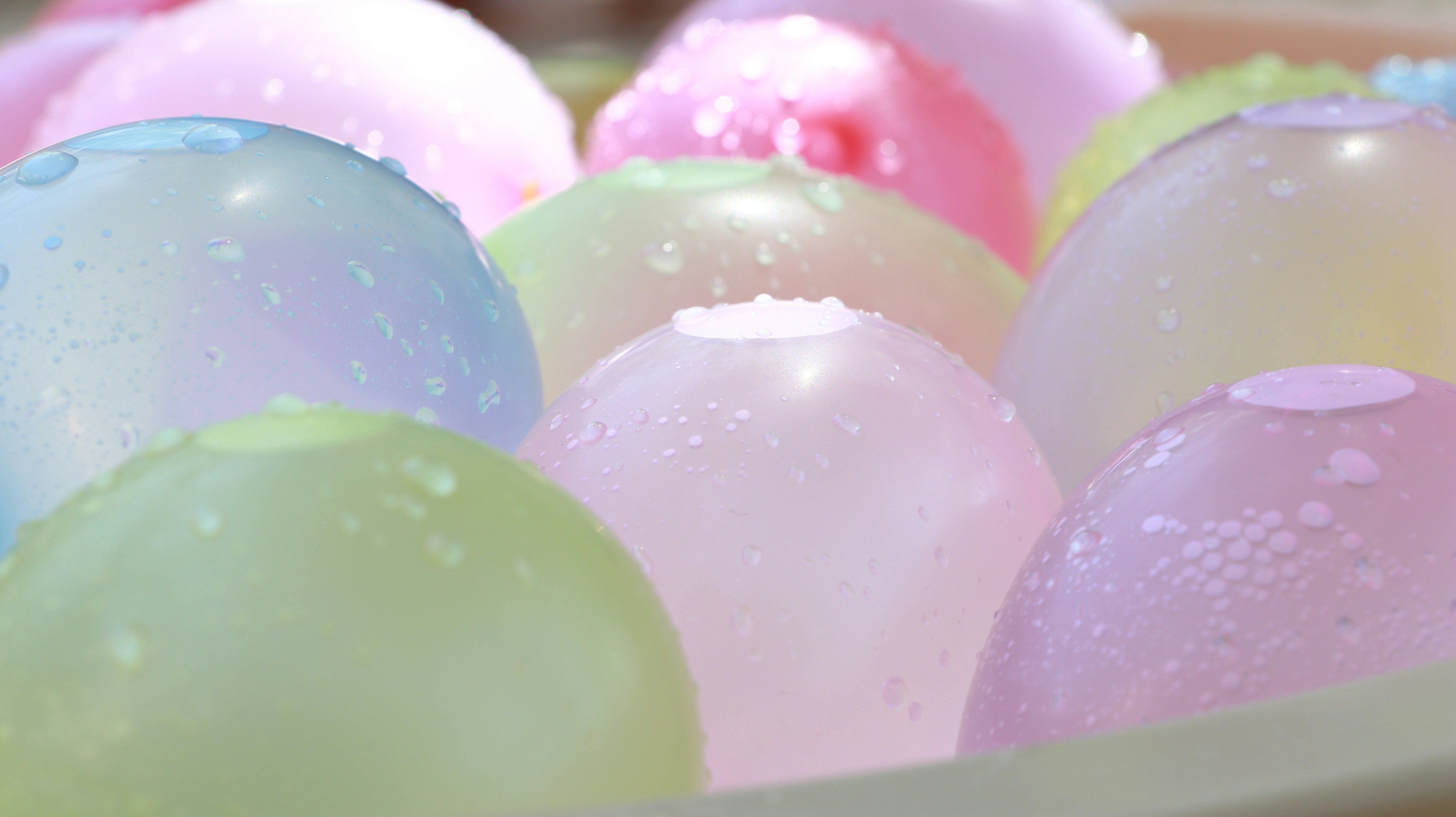 Here's a caption: water balloons in a variety of pastel colors. photo ...