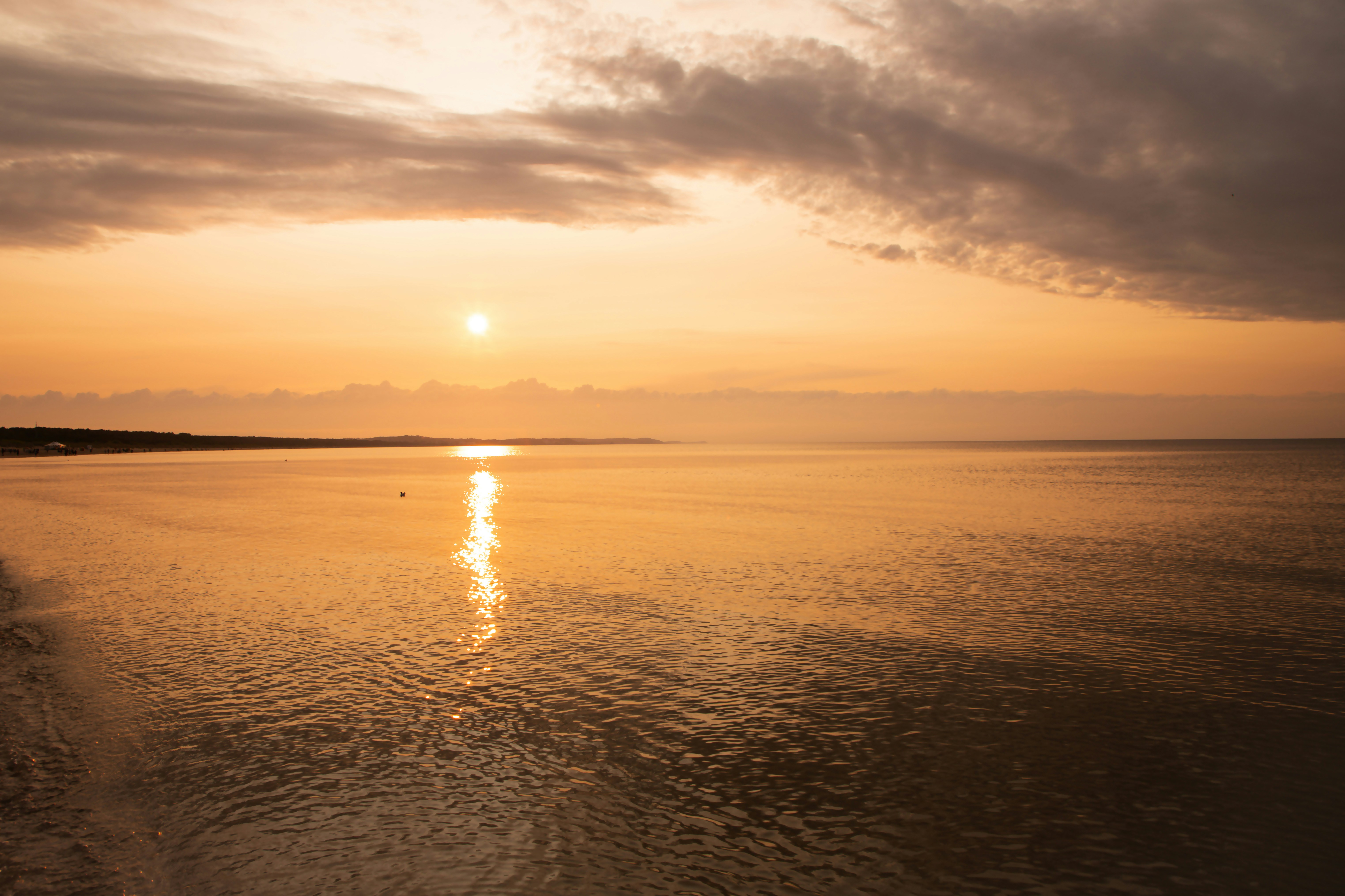 Sunset casts golden reflections on calm water.MARIOLA GROBELSKA