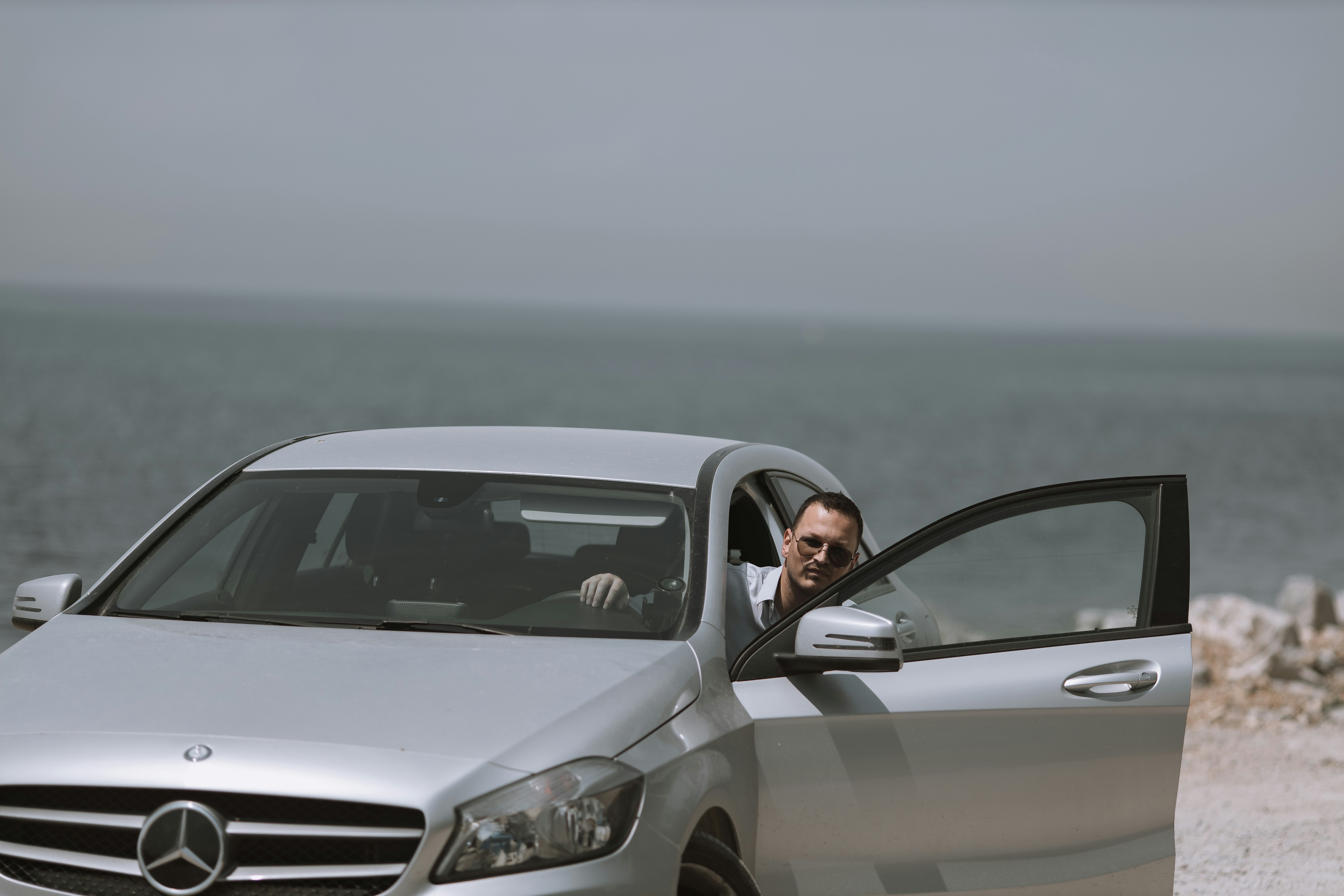 Seaside Stop: A Quiet Moment with a Silver Mercedes by the Breakwater