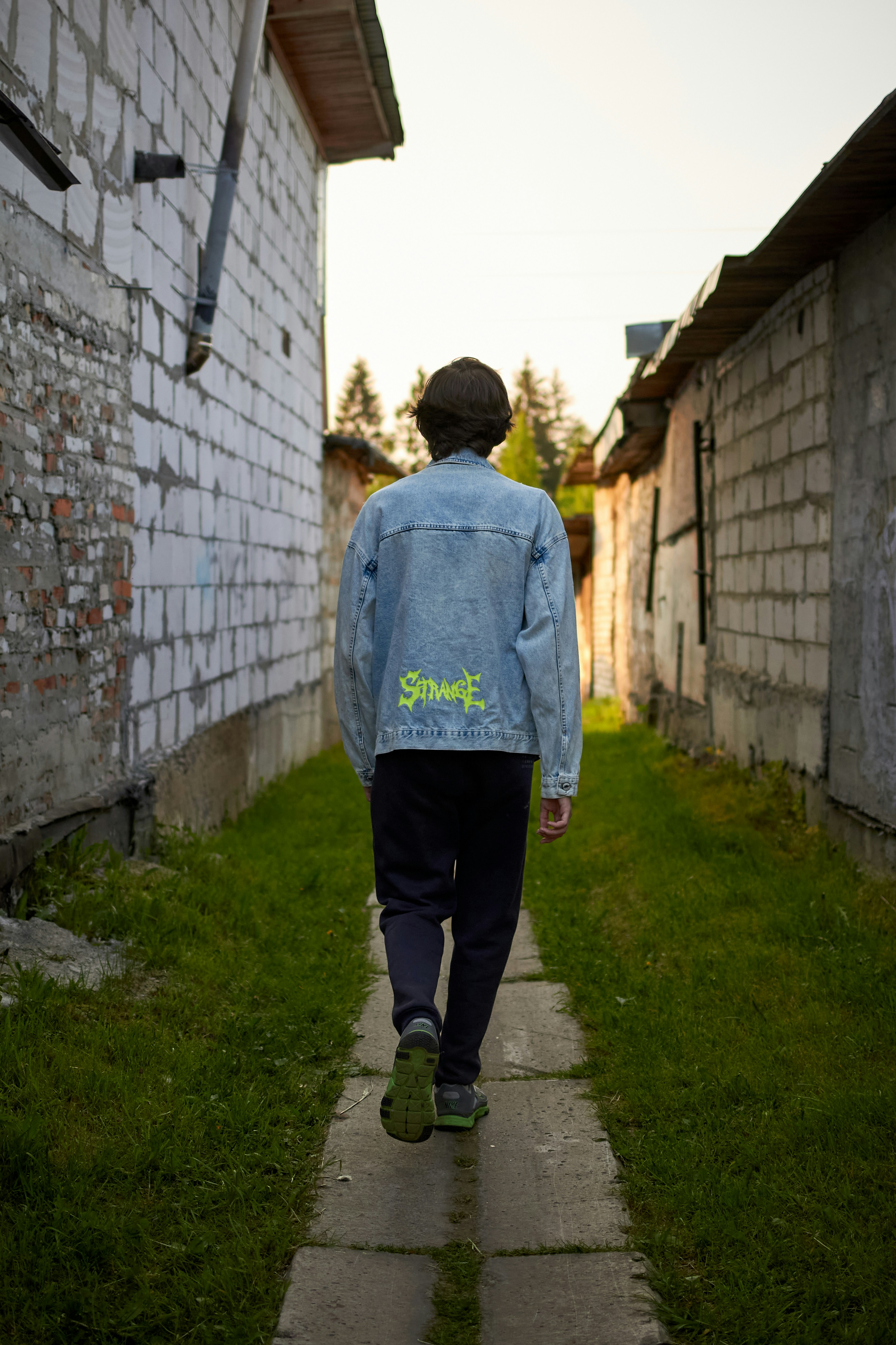 A person walks down a narrow alley.