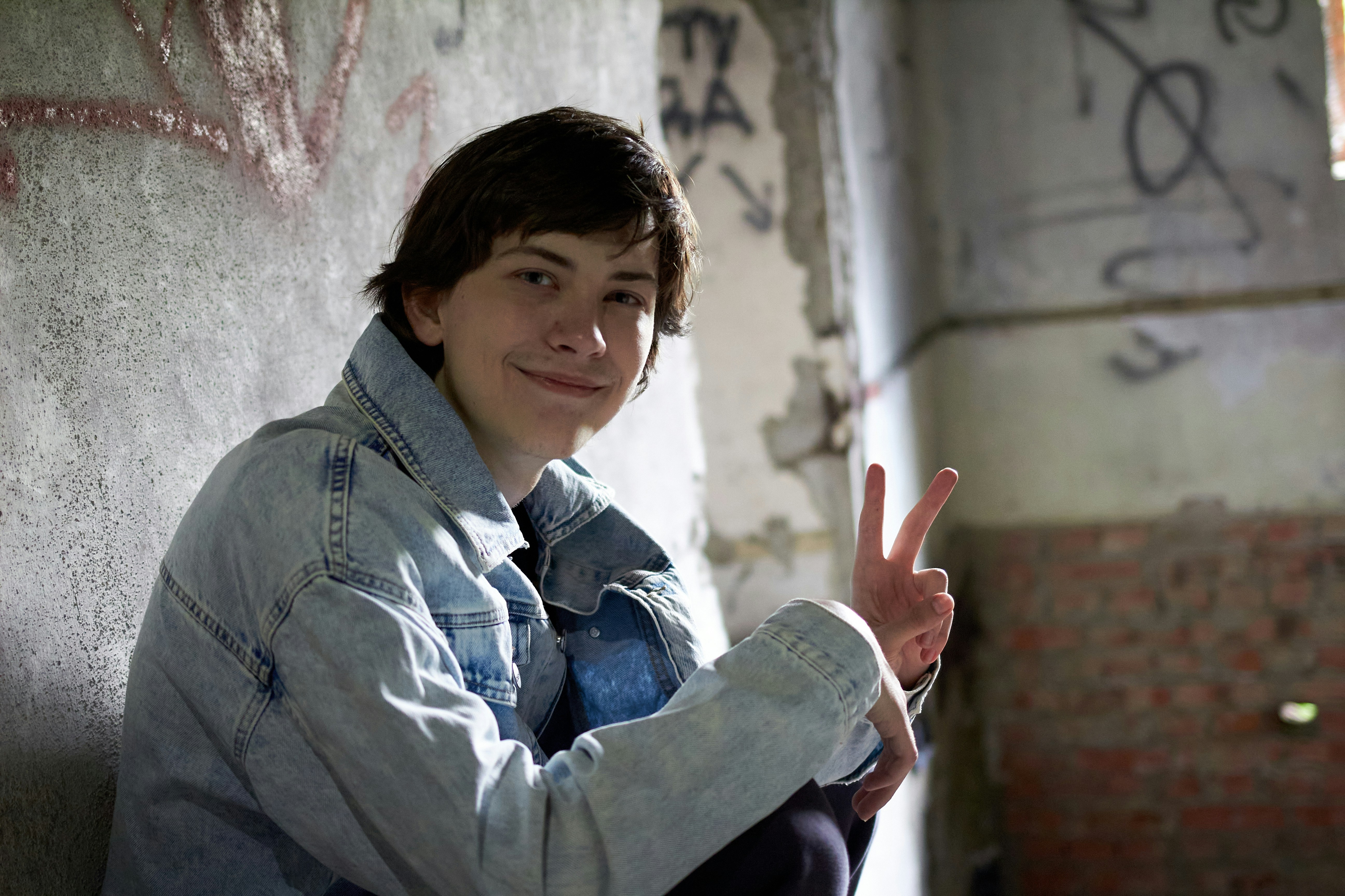 Young person smiles, giving a peace sign. photo – Free Portrait Image ...