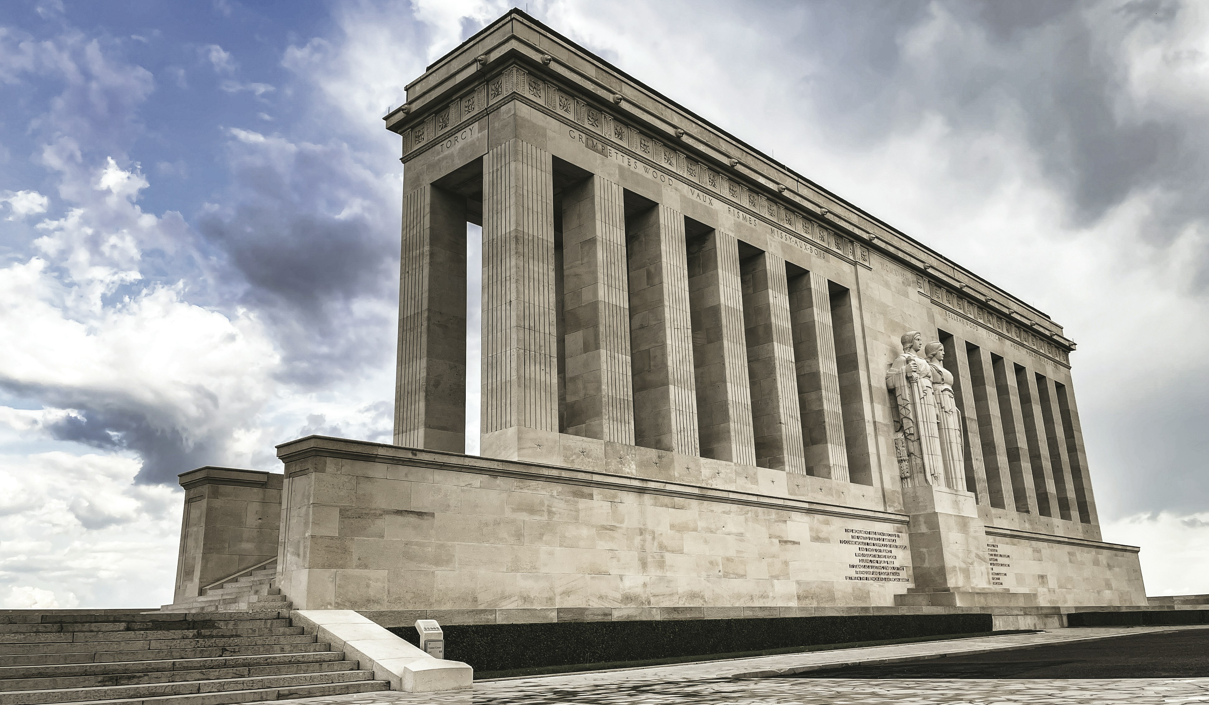 Imposing stone monument with towering columns and a statue, set against a dramatic sky. A testament to architectural grandeur and historical significance.