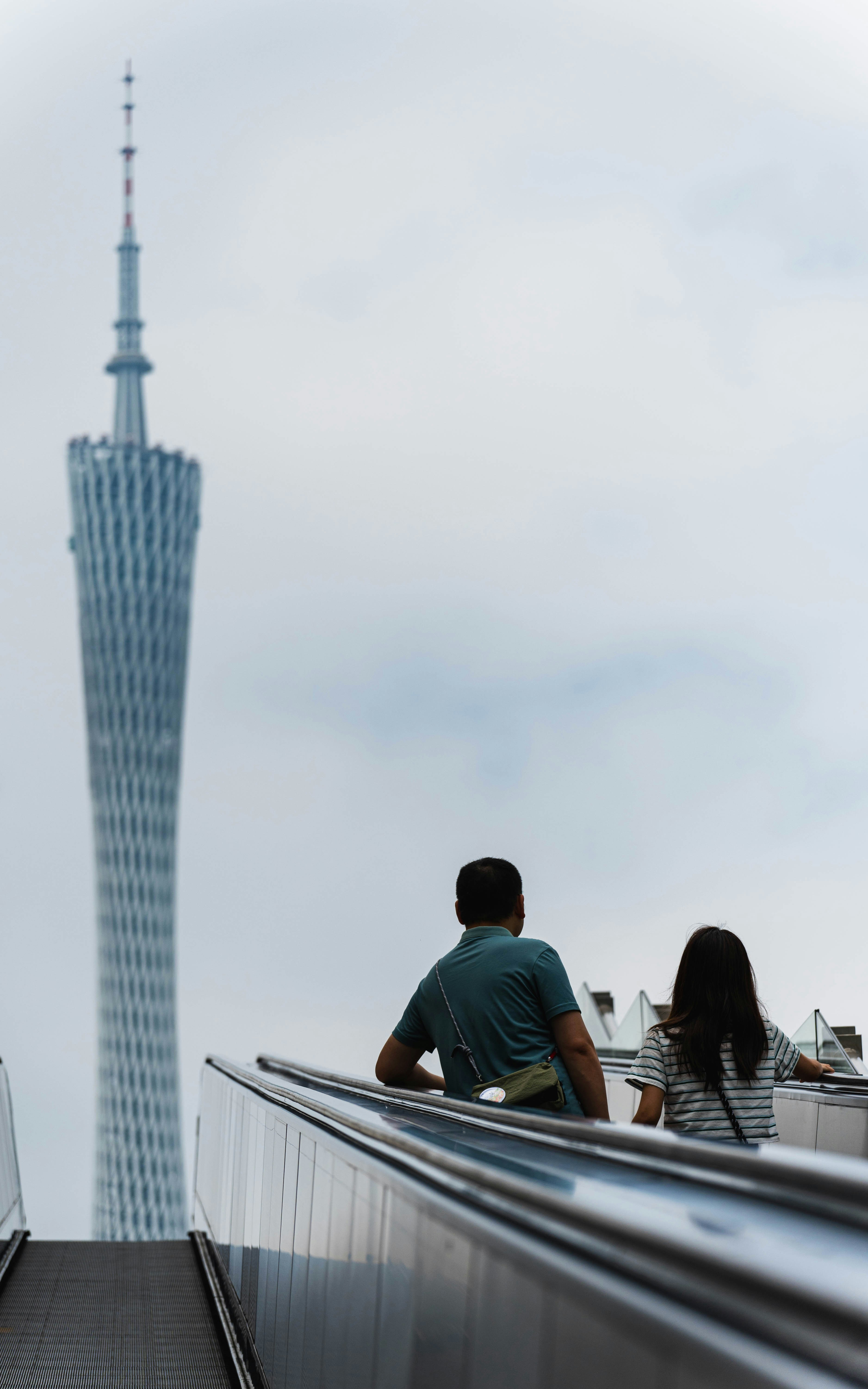 Escalator to the Sky: Friends Ascend with Tokyo Skyscraper in the Distance