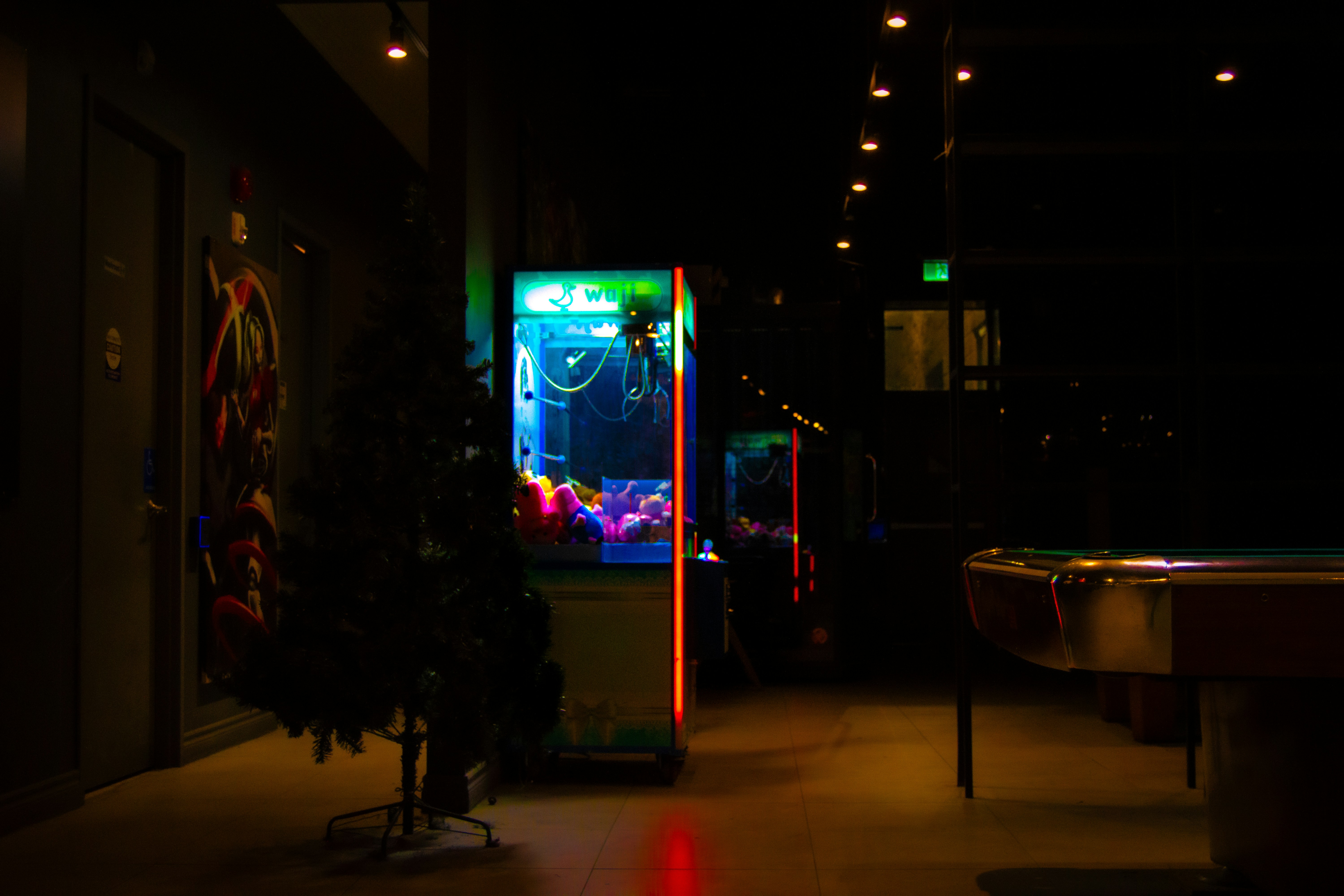 A dark arcade, illuminated by colorful lights. photo – Free Night Image ...