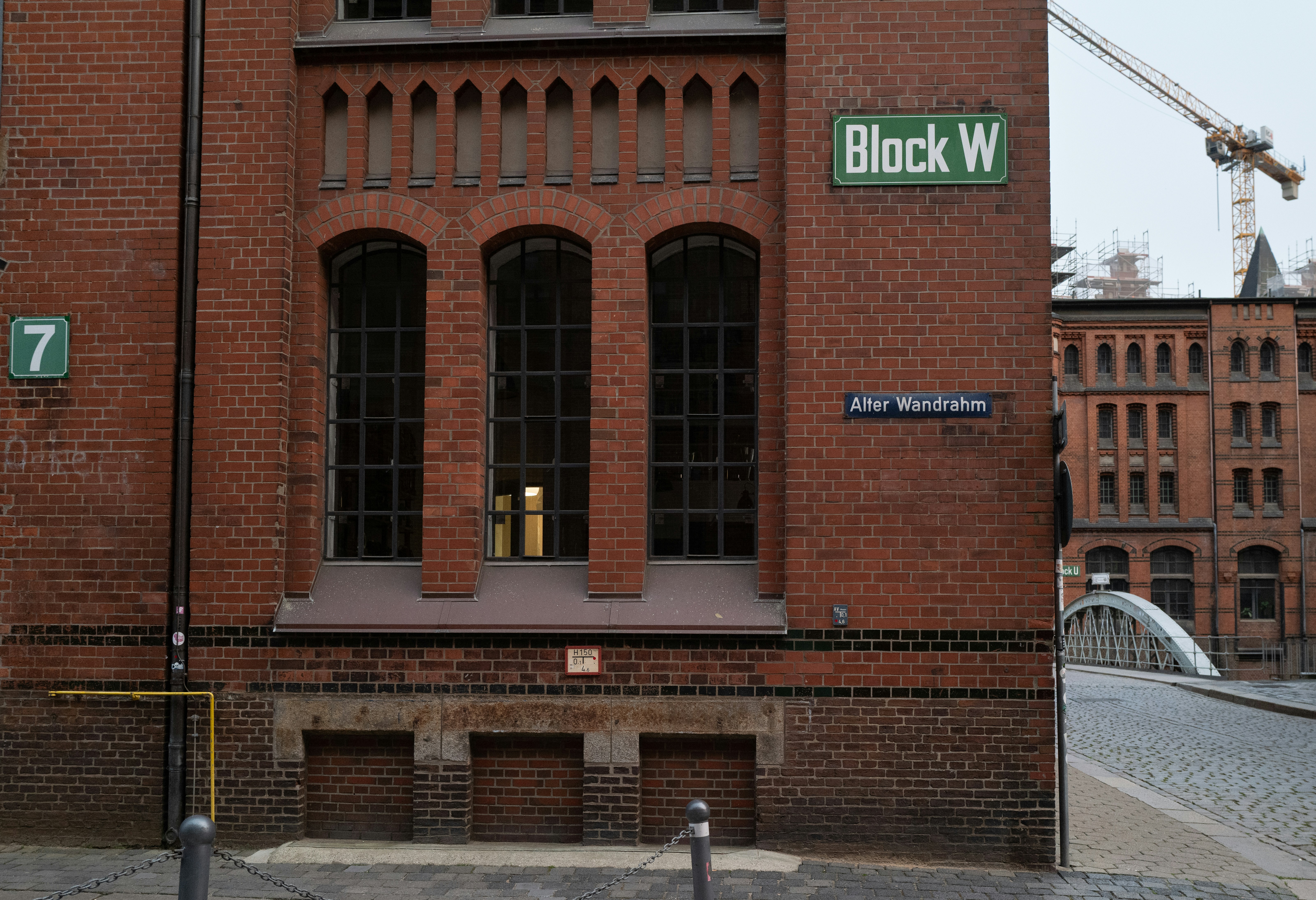 Block W Facade: Arched Brickwork Framing a Distant Riverside Bridge
