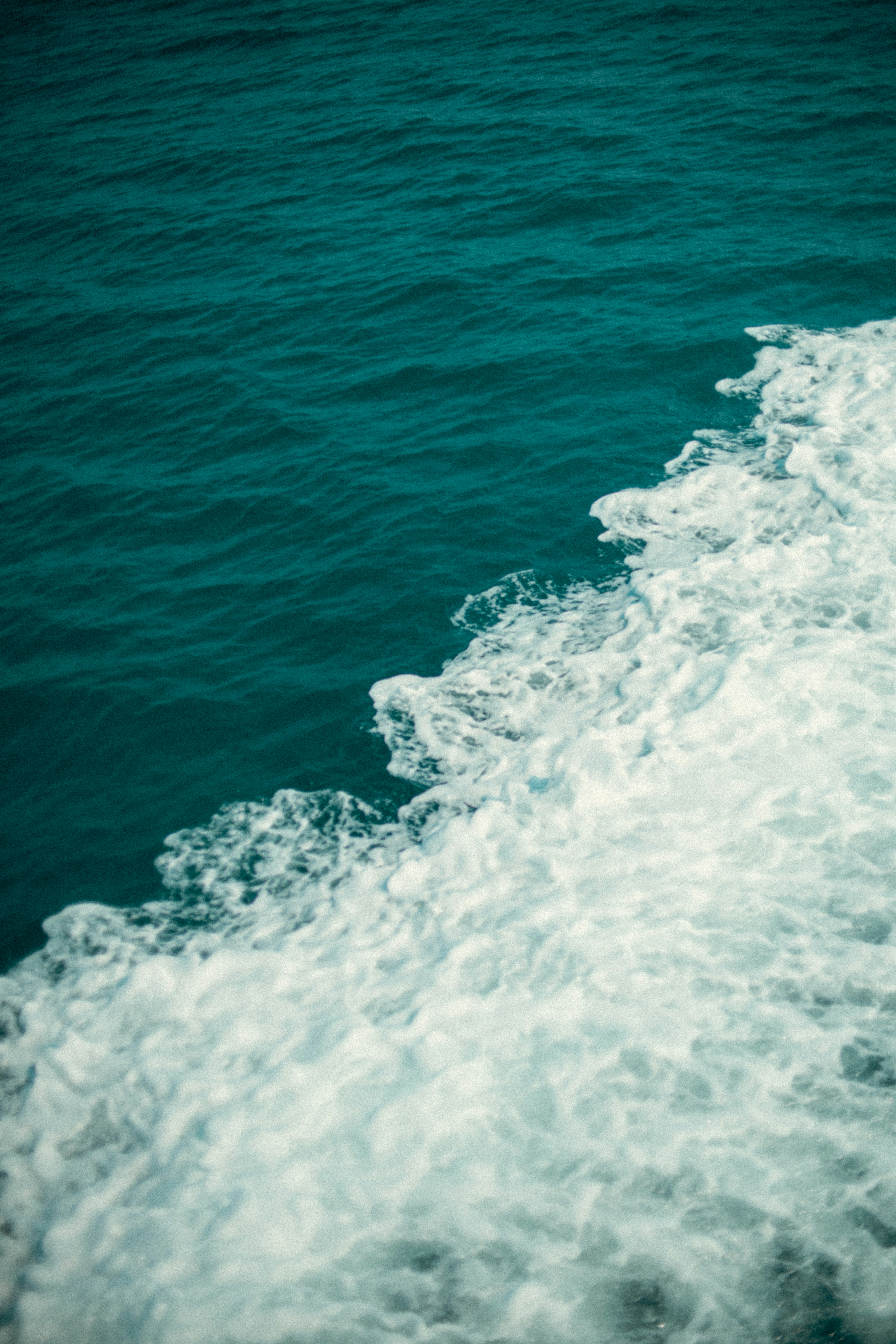Turquoise ocean water with foamy white waves.