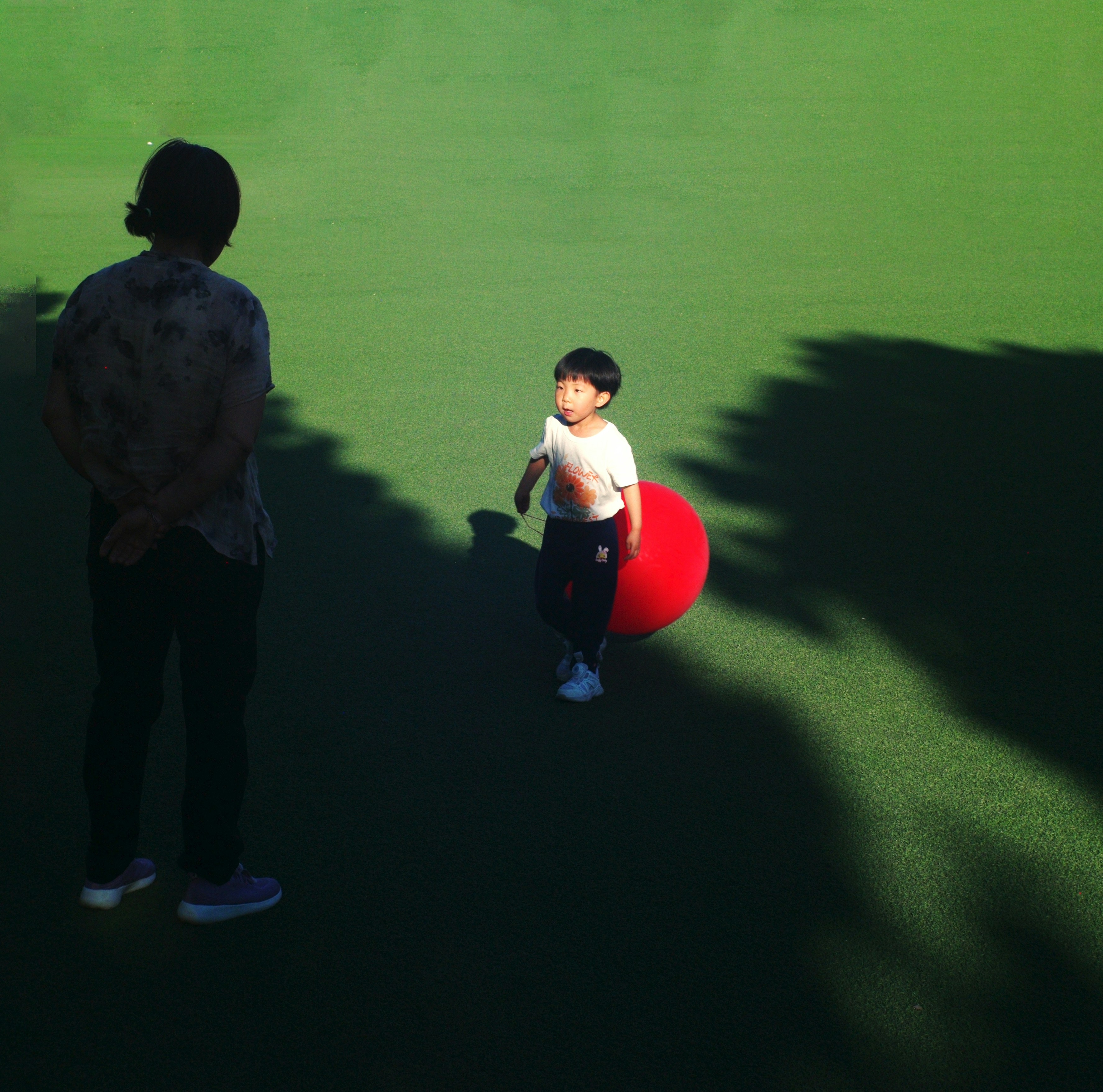 A child plays with a red ball.