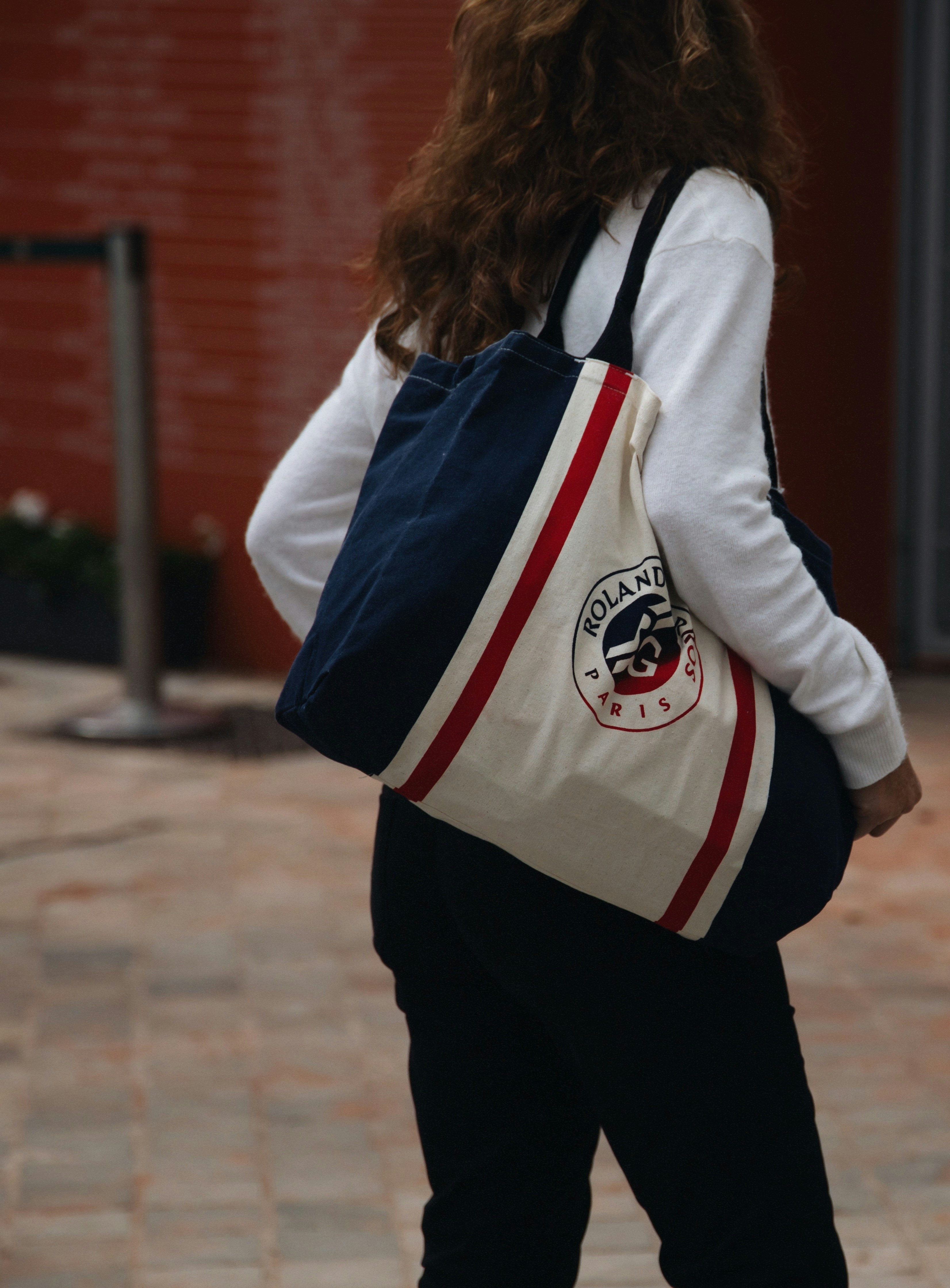 Roland Garros | A person carries a bag with a logo.