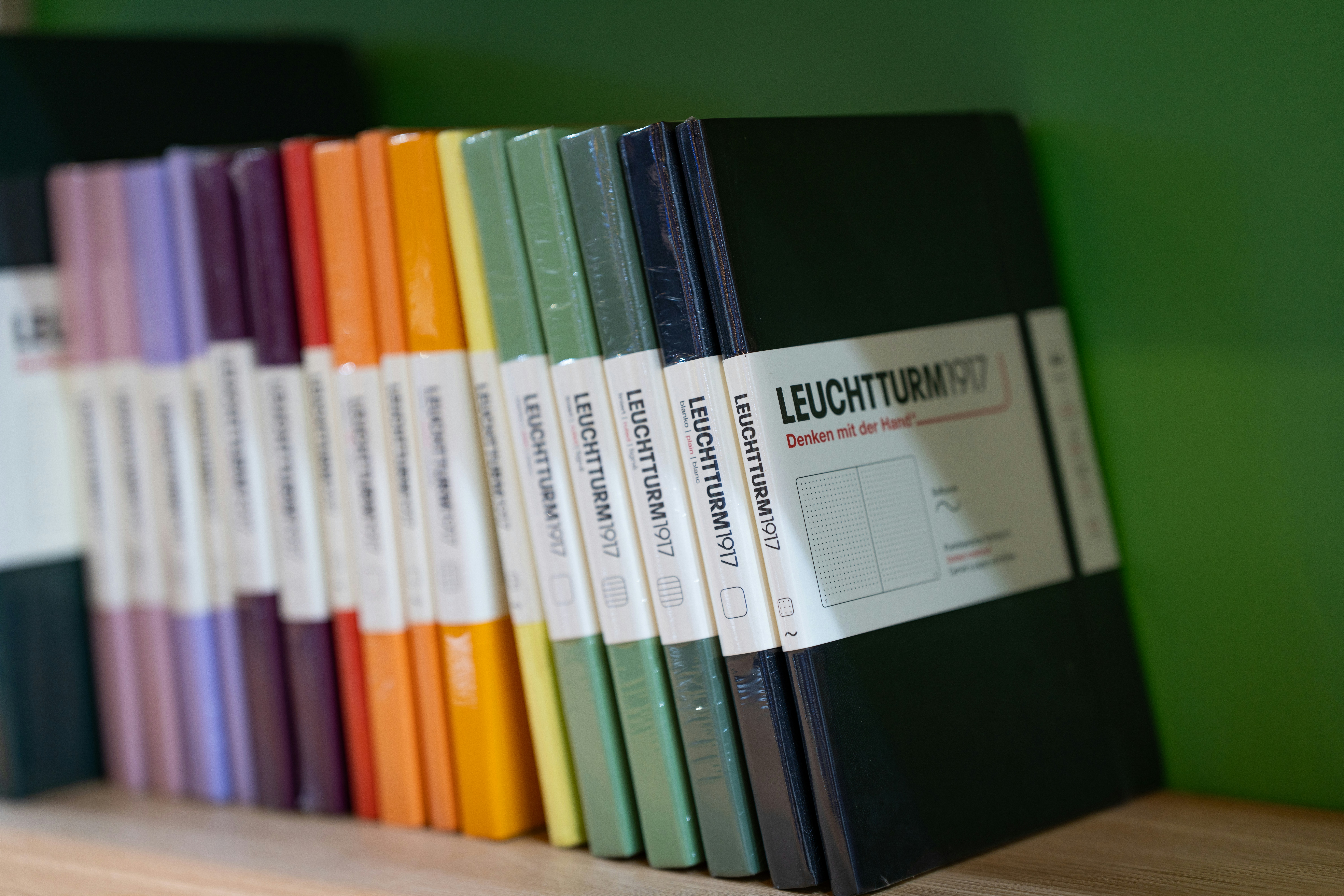A row of colorful notebooks are on display. photo – Free Green Image on ...
