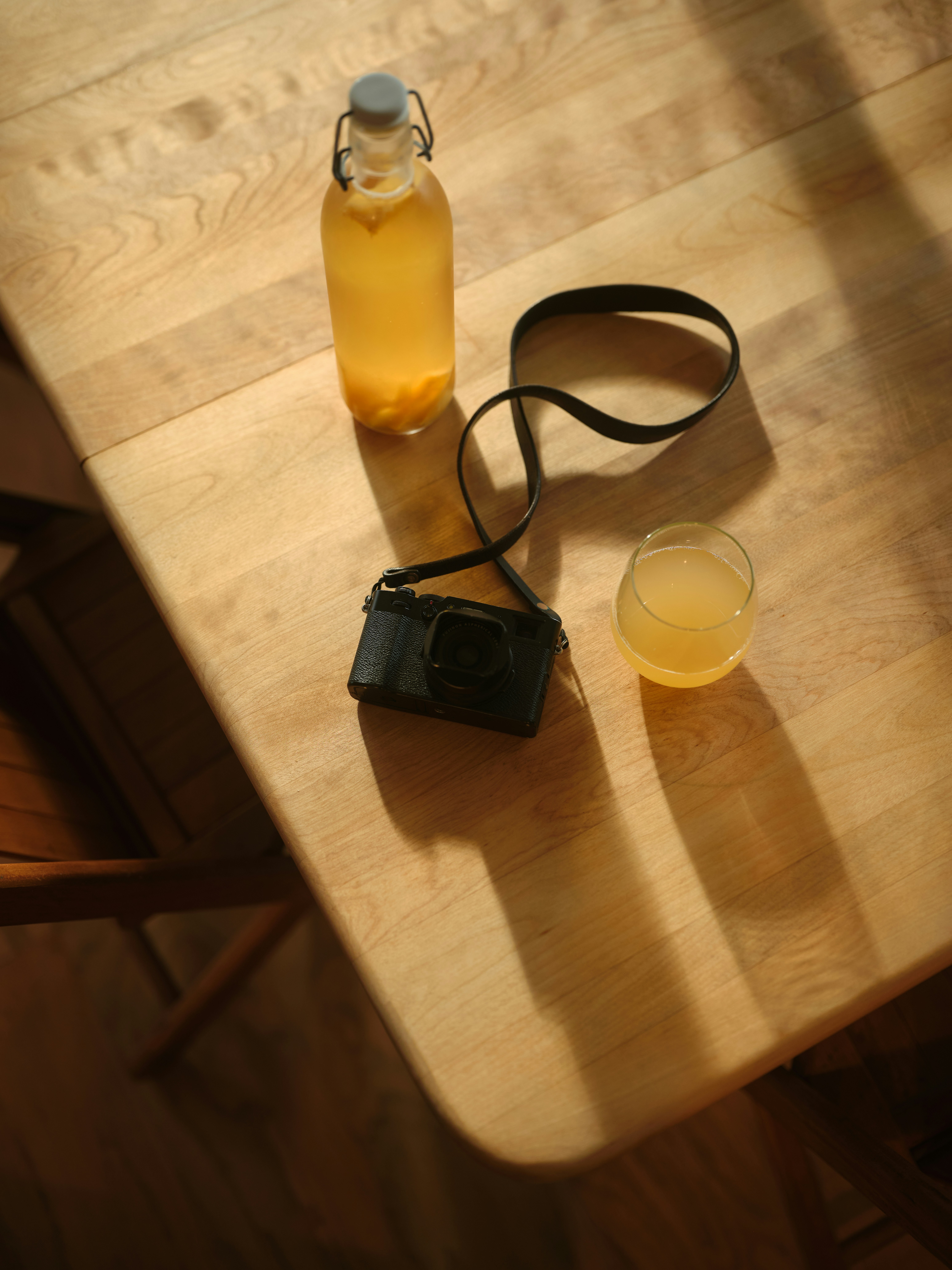 Bottle, camera, and drink are resting on a table. photo – Free ...