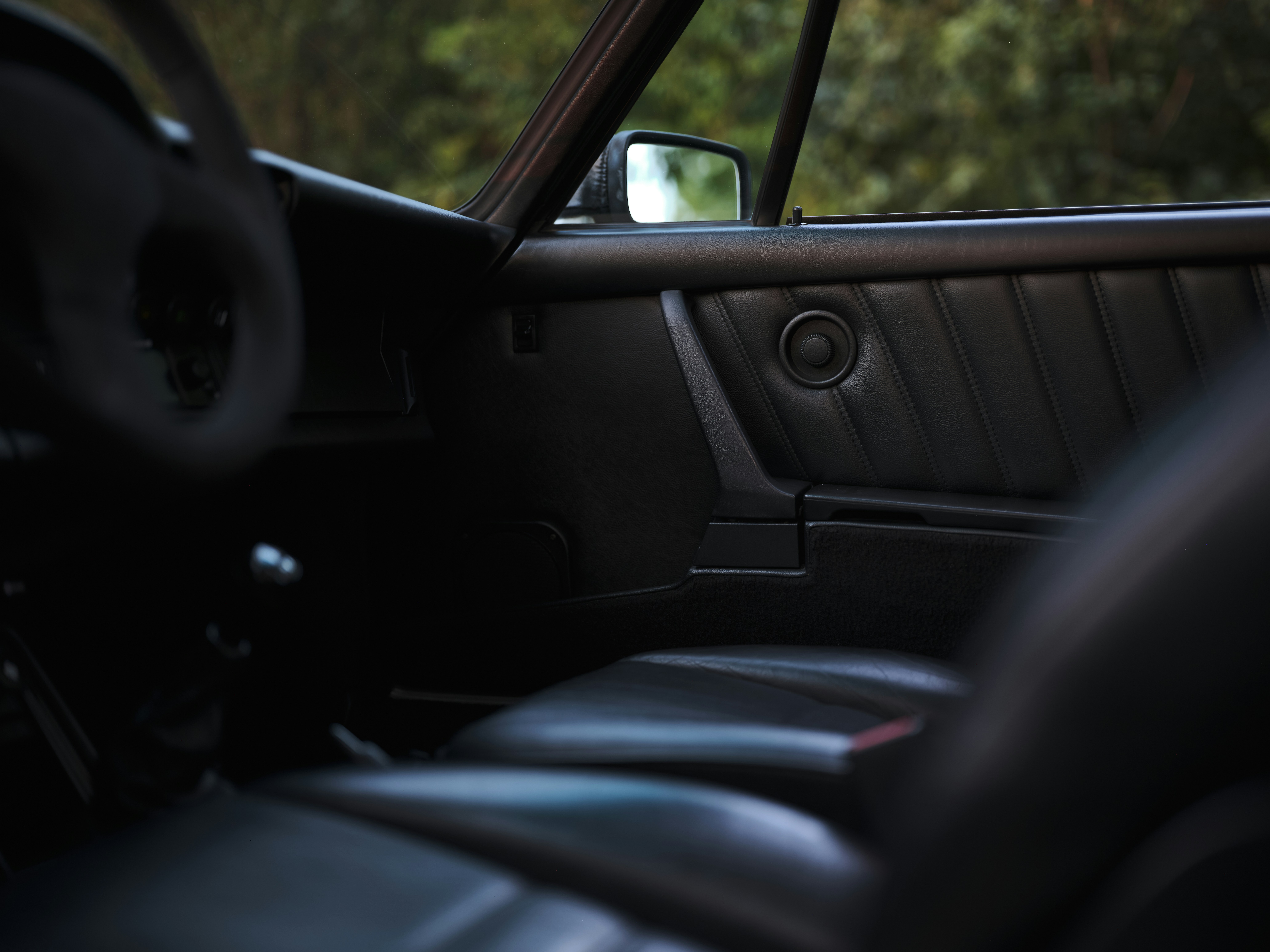 Interior of a classic car showcasing sleek black leather seats and dashboard details.